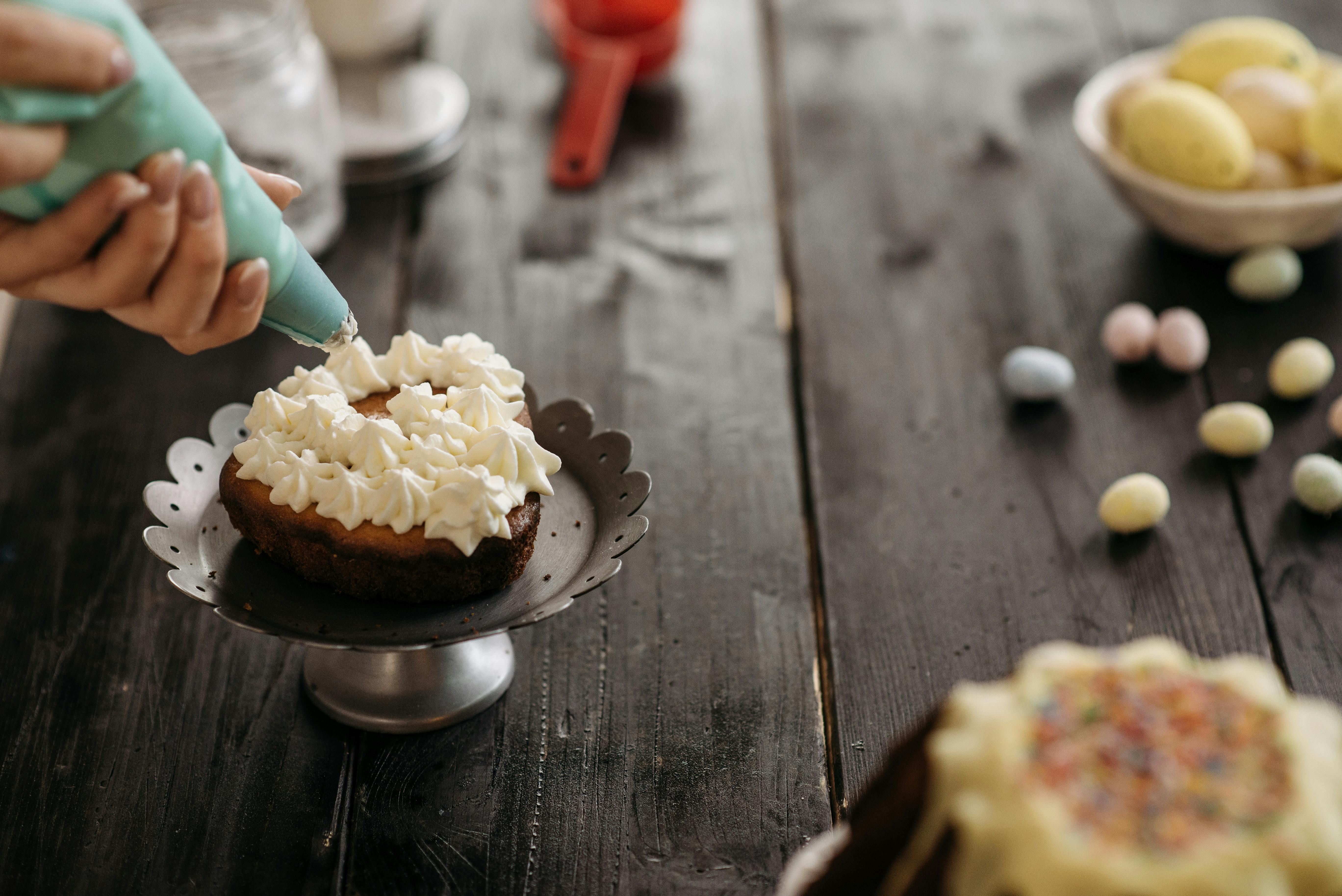 Person Putting an Icing on Top of a Cake Slice · Free Stock Photo