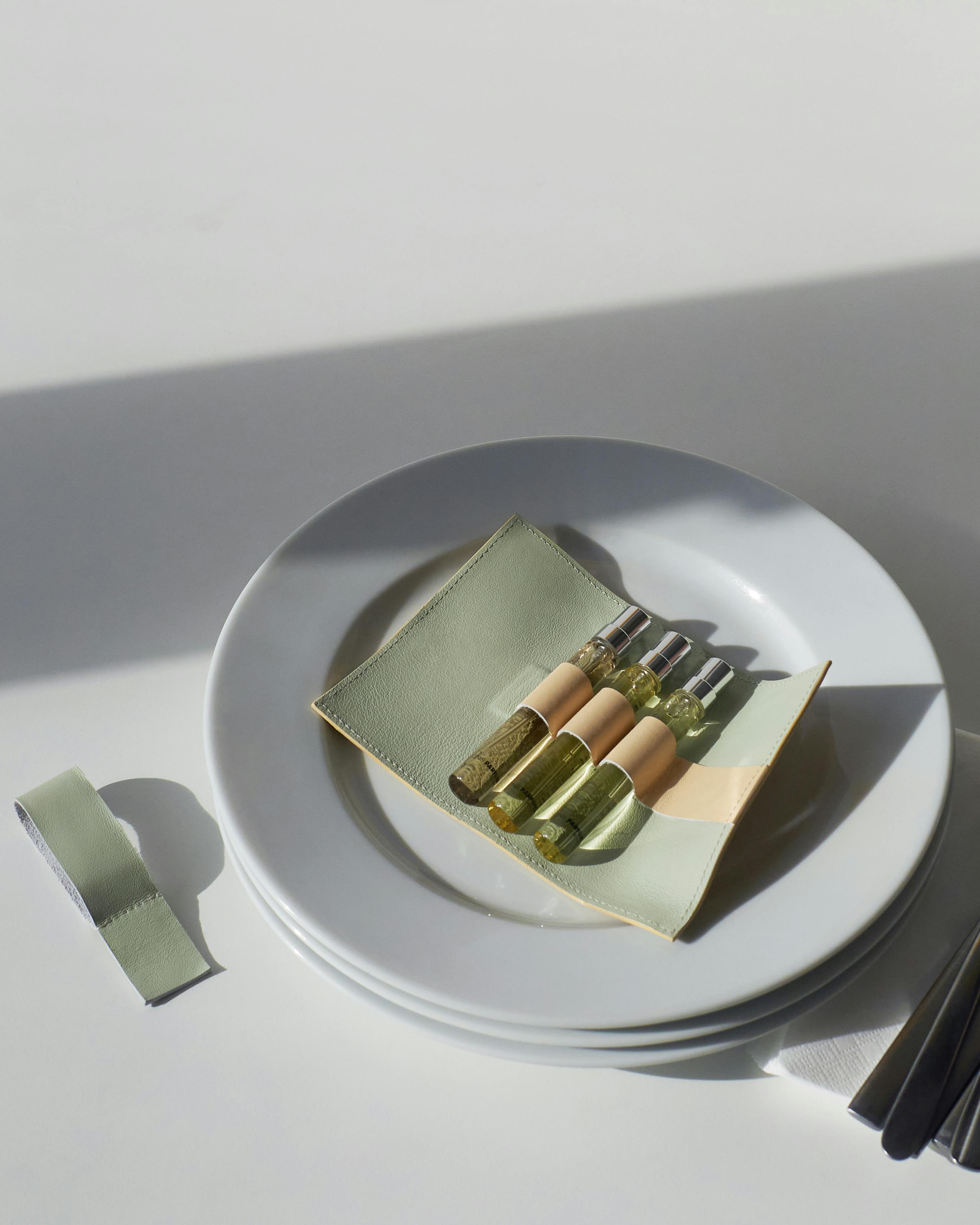 Small Perfume Bottle Set on White Ceramic Round Plate · Free Stock Photo