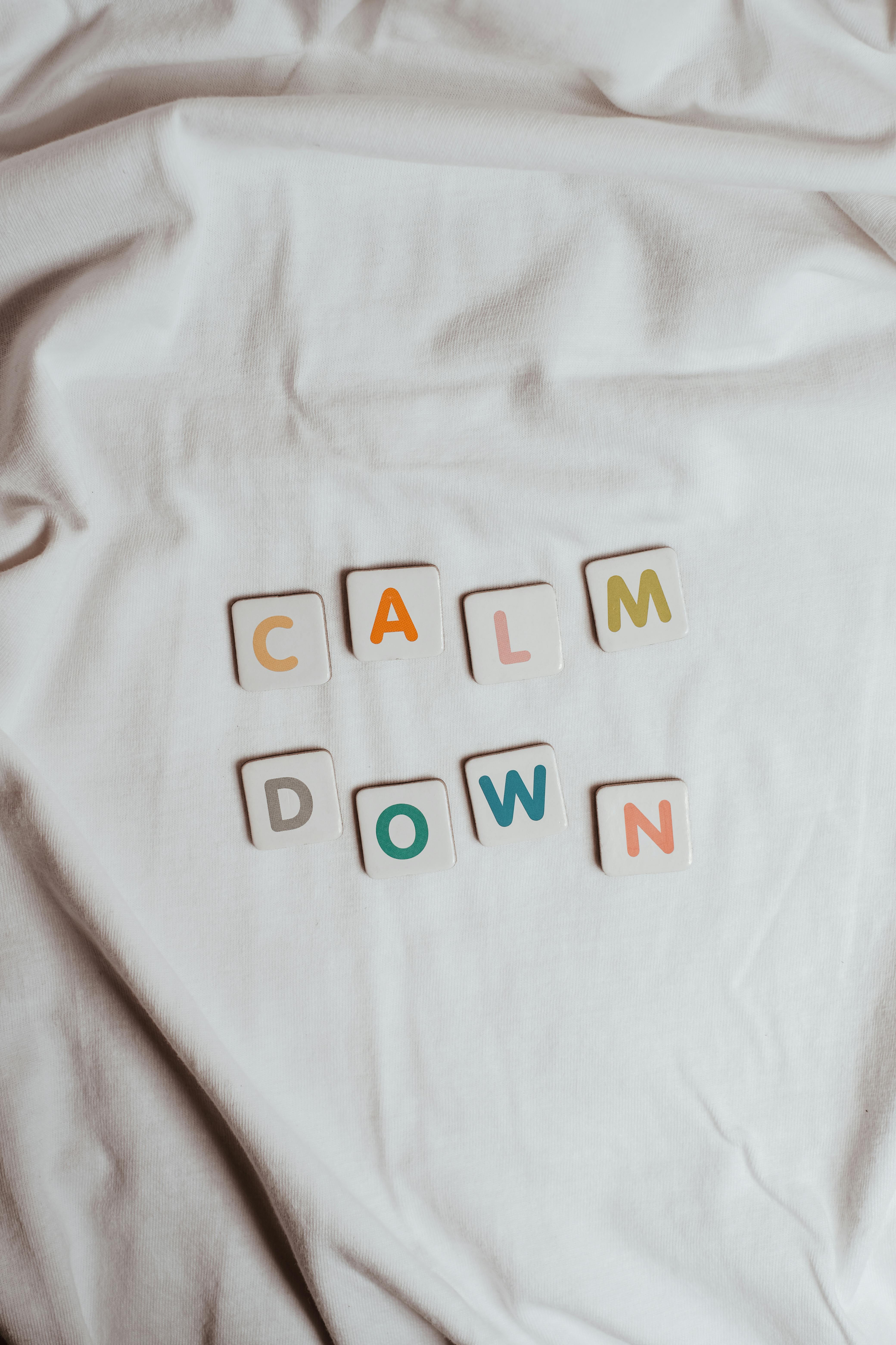 The Phrase Calm Down on a Sheet of Fabric · Free Stock Photo