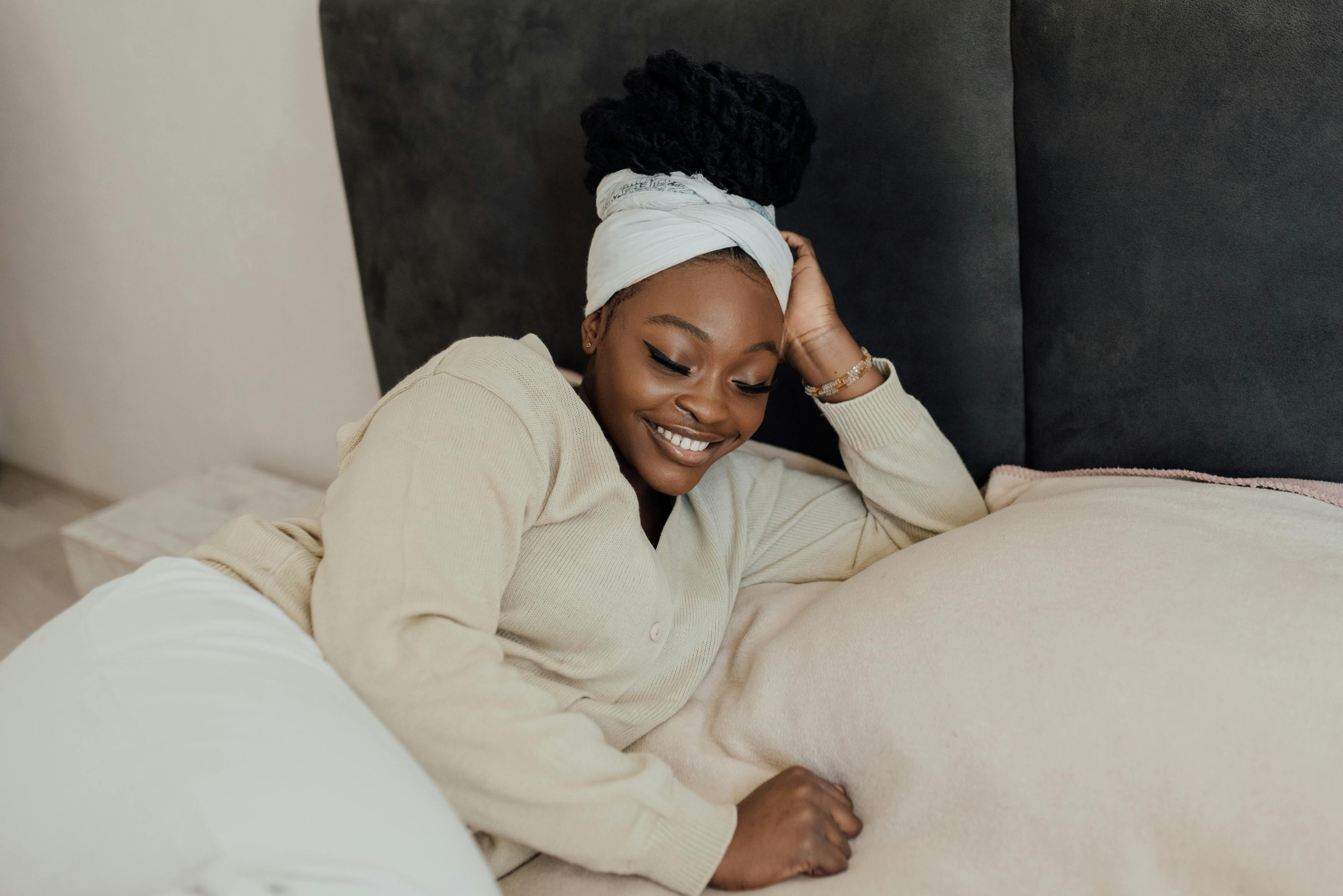 A Happy Woman Lying on a Bed · Free Stock Photo