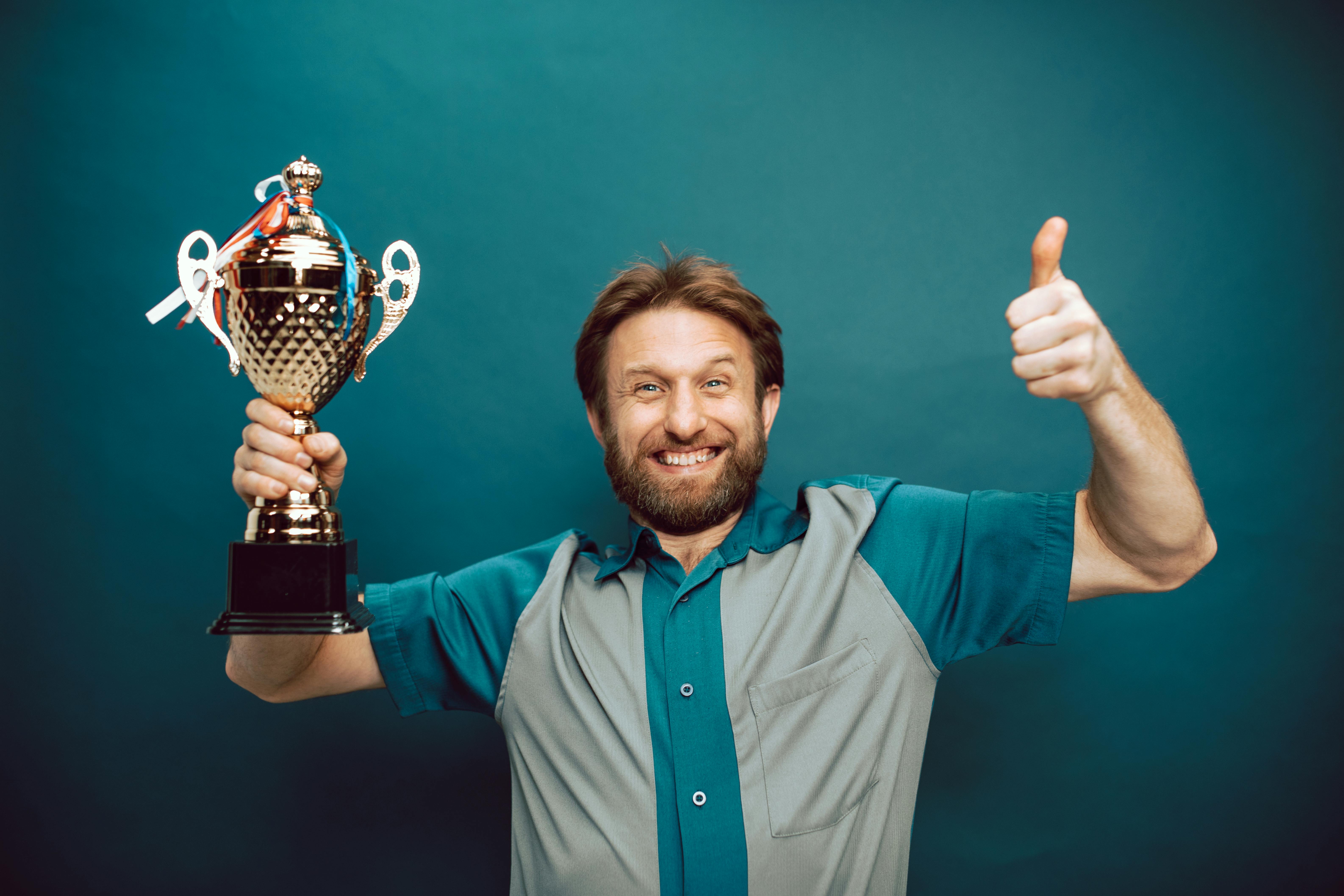 A Man's Face of Victory Holding His Trophy · Free Stock Photo