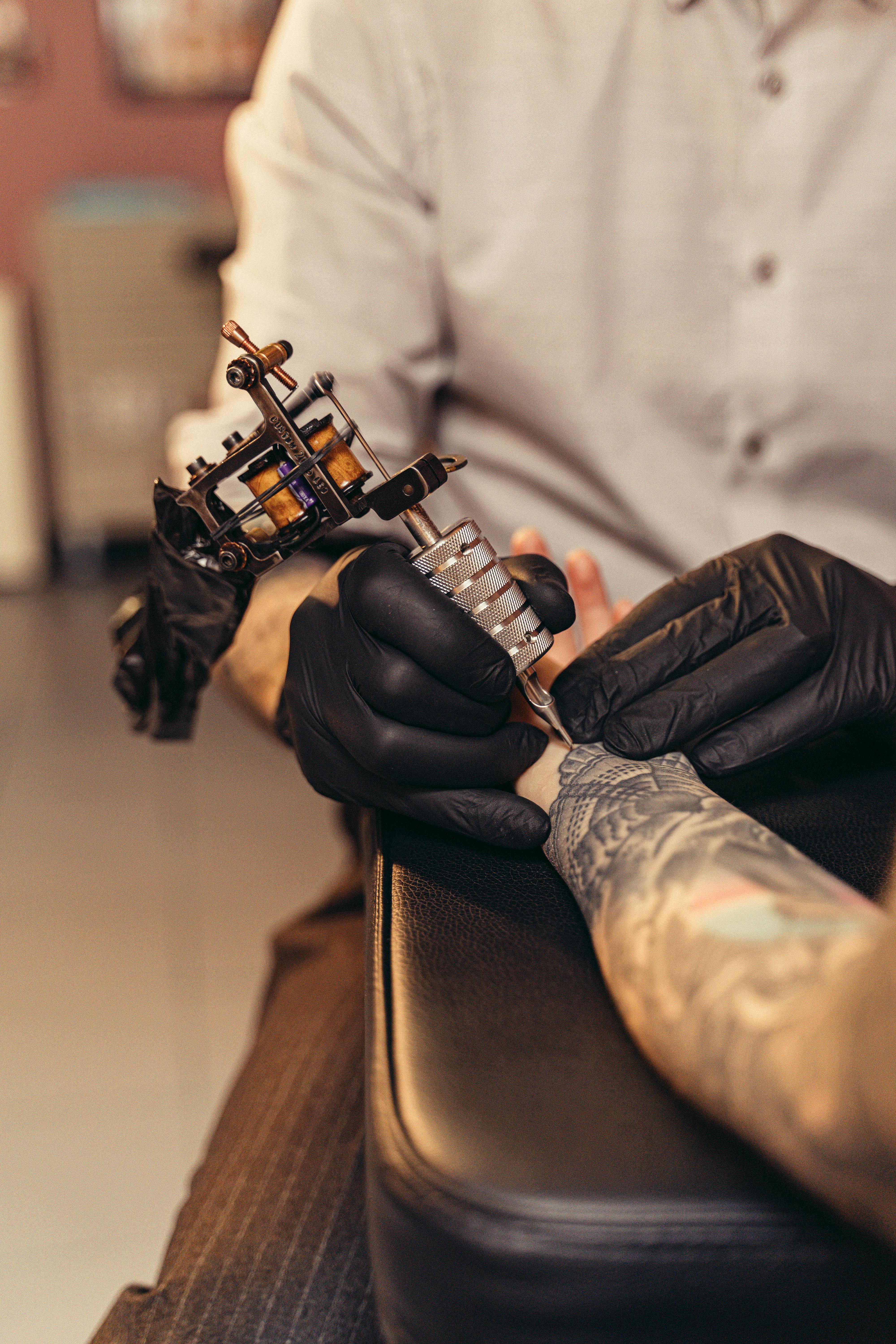 A Tattoo Artist Tattooing a Client's Arm · Free Stock Photo