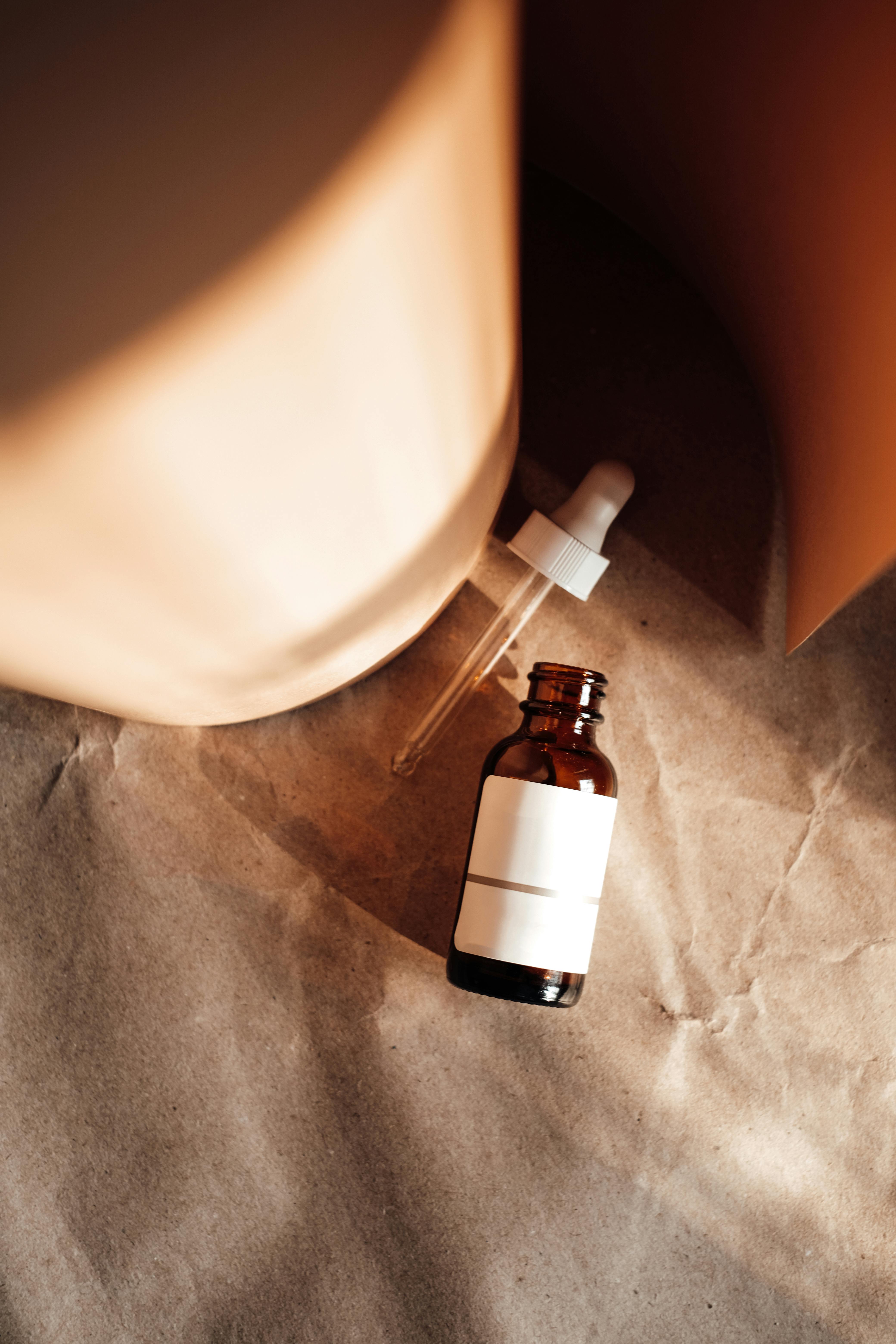 A Dropper and a Bottle on the Brown Paper · Free Stock Photo