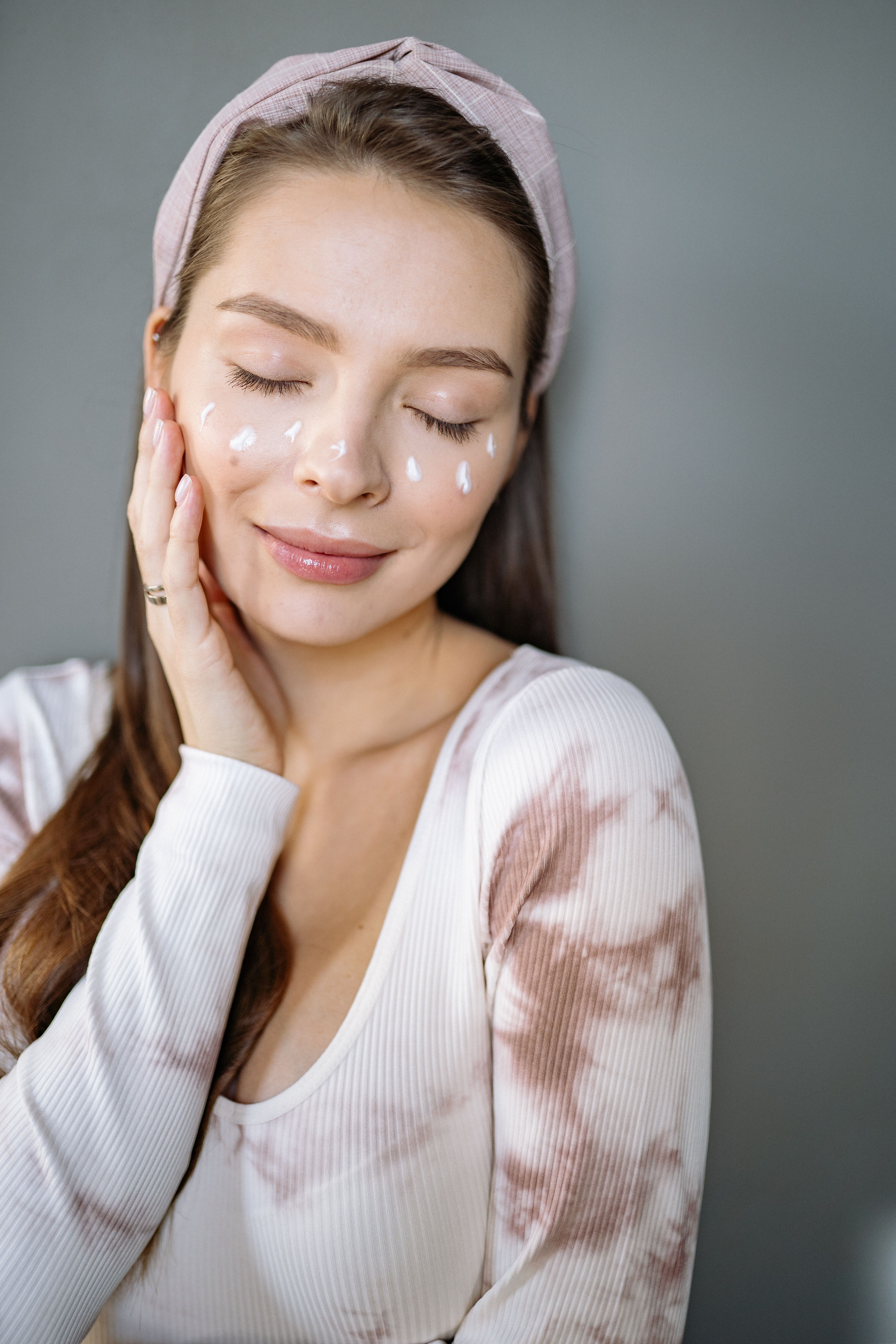Woman Applying Skincare on Her Face · Free Stock Photo