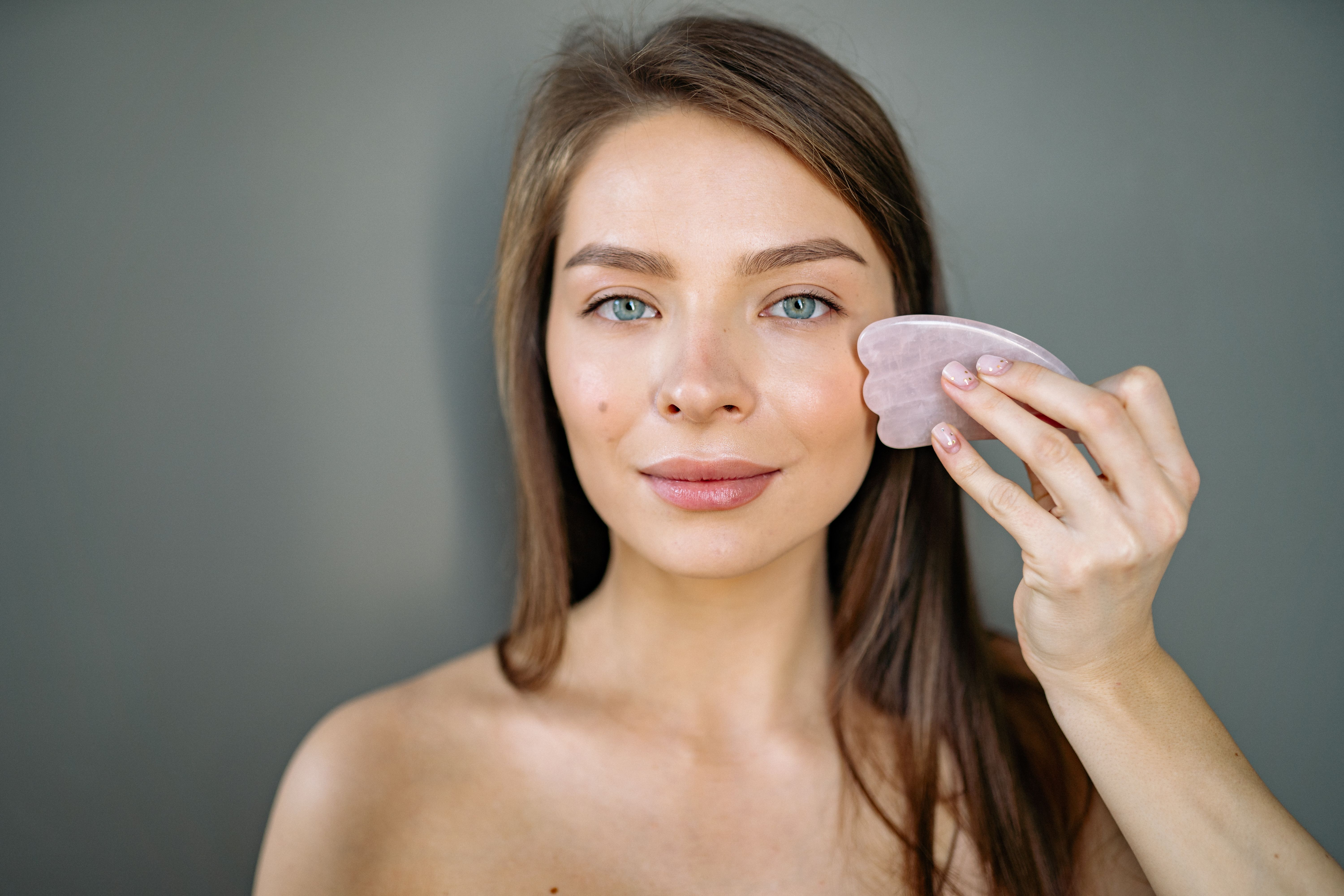 A Woman Using a Gua Sha · Free Stock Photo