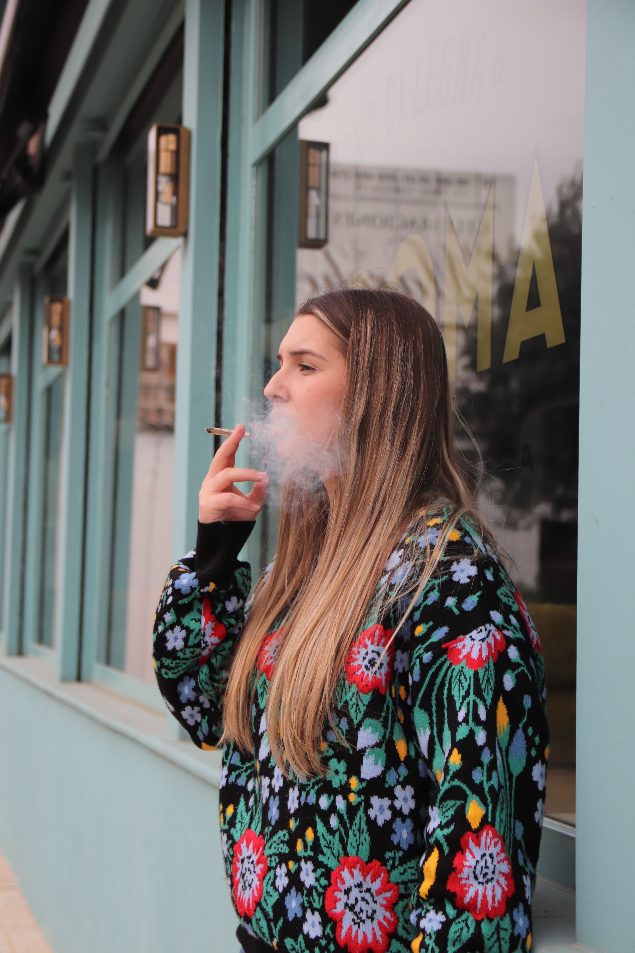 A Woman in Floral Sweater Smoking a Cigarette · Free Stock Photo