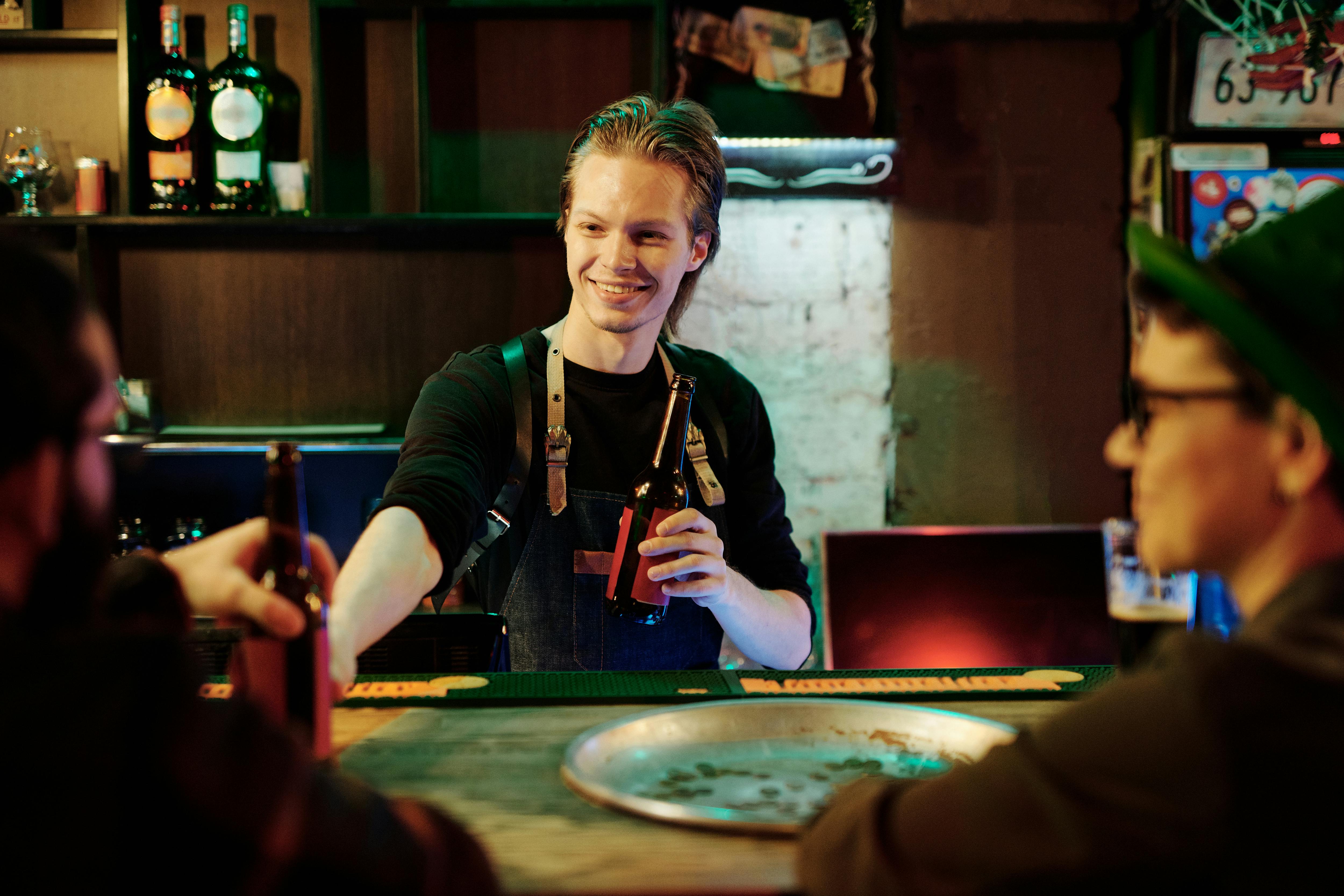 Bartender handing out Beer Bottles · Free Stock Photo