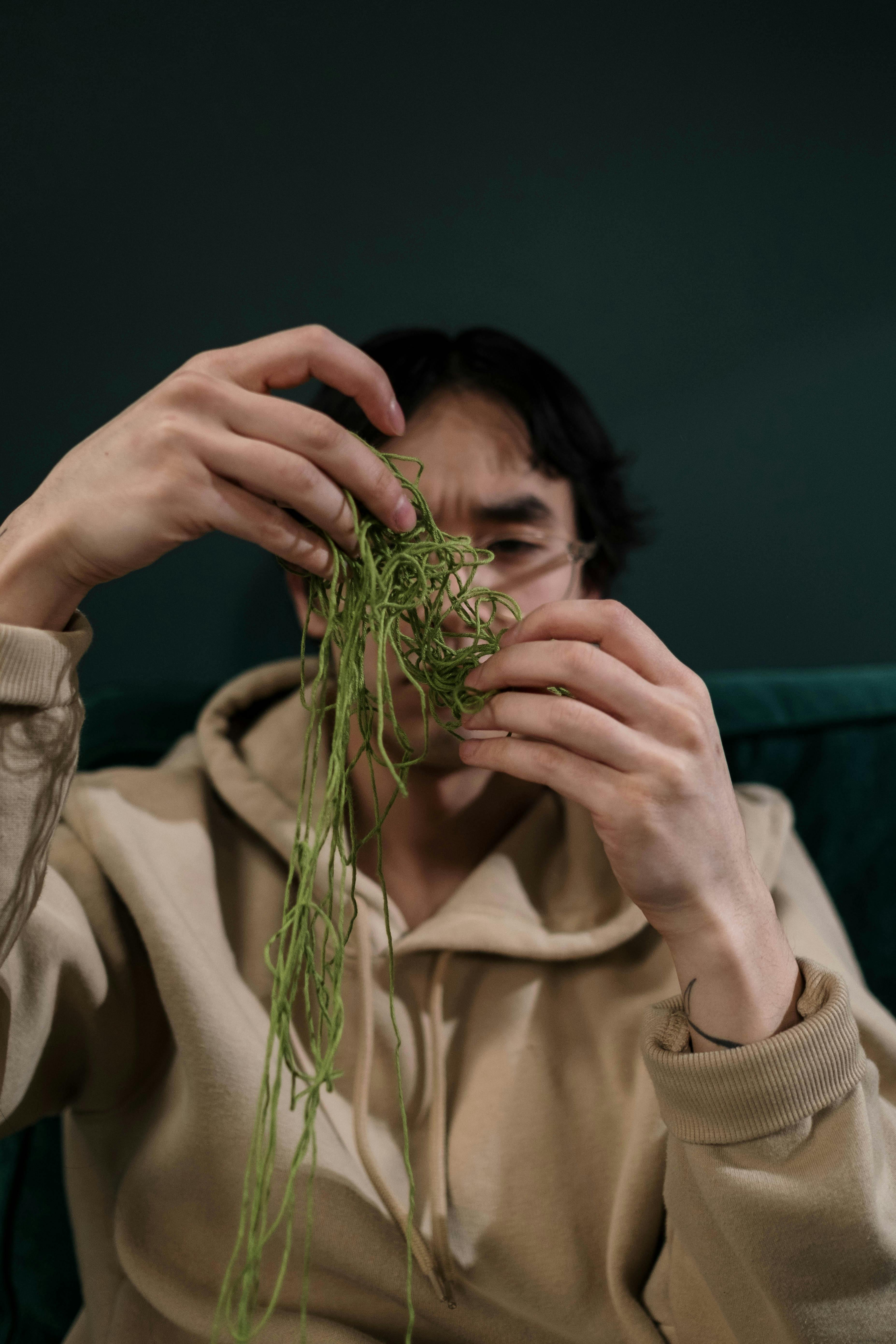 Man Holding Green Thread · Free Stock Photo