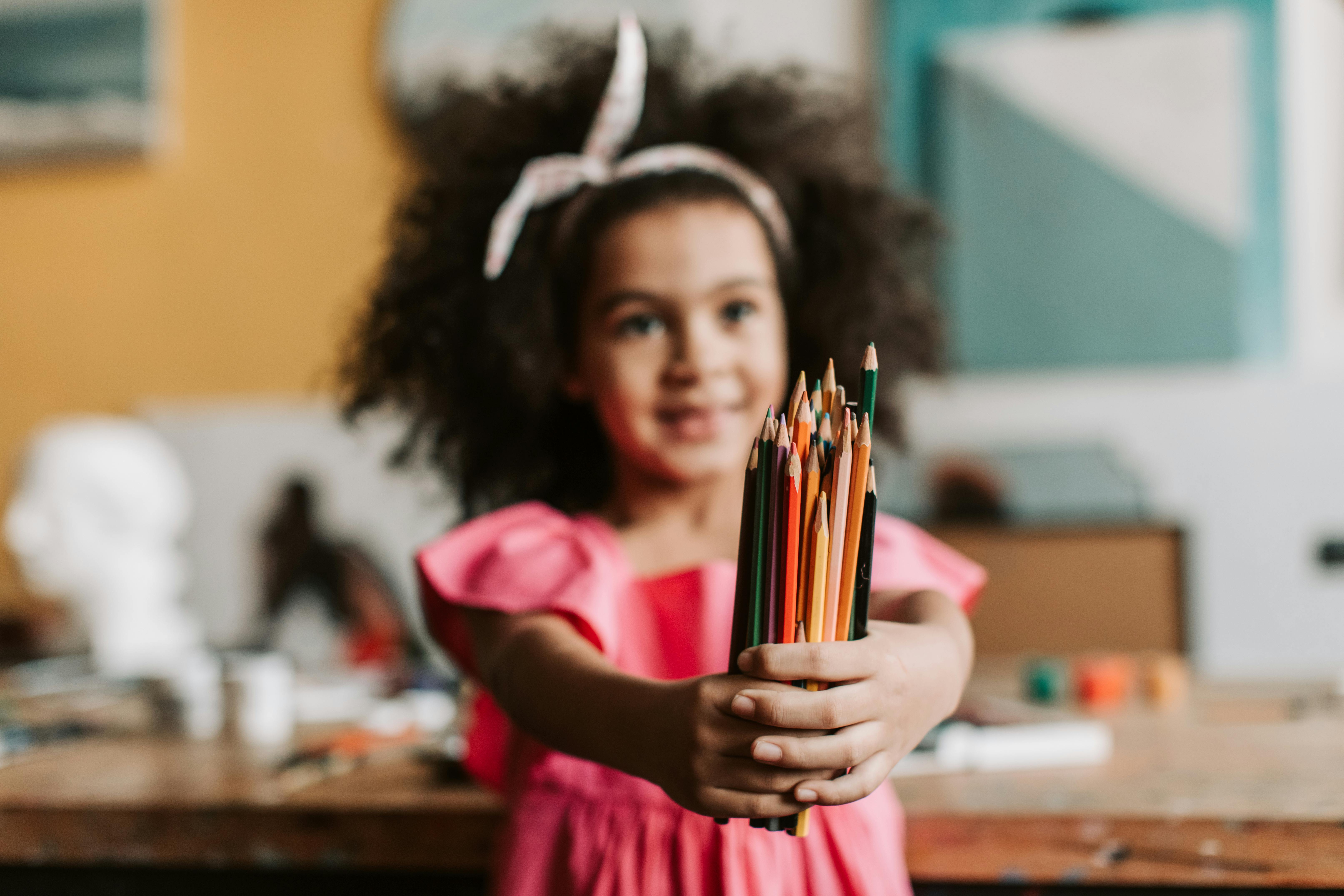 Photograph of a Girl Holding Colored Pencils · Free Stock Photo