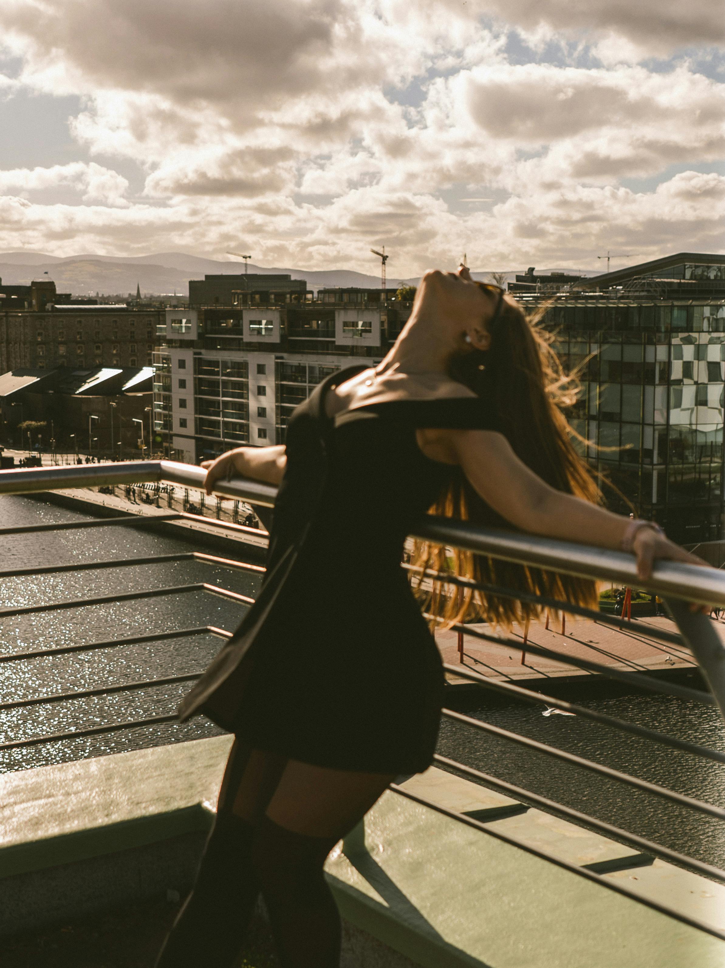 Woman in a Black Dress Leaning on Railings · Free Stock Photo
