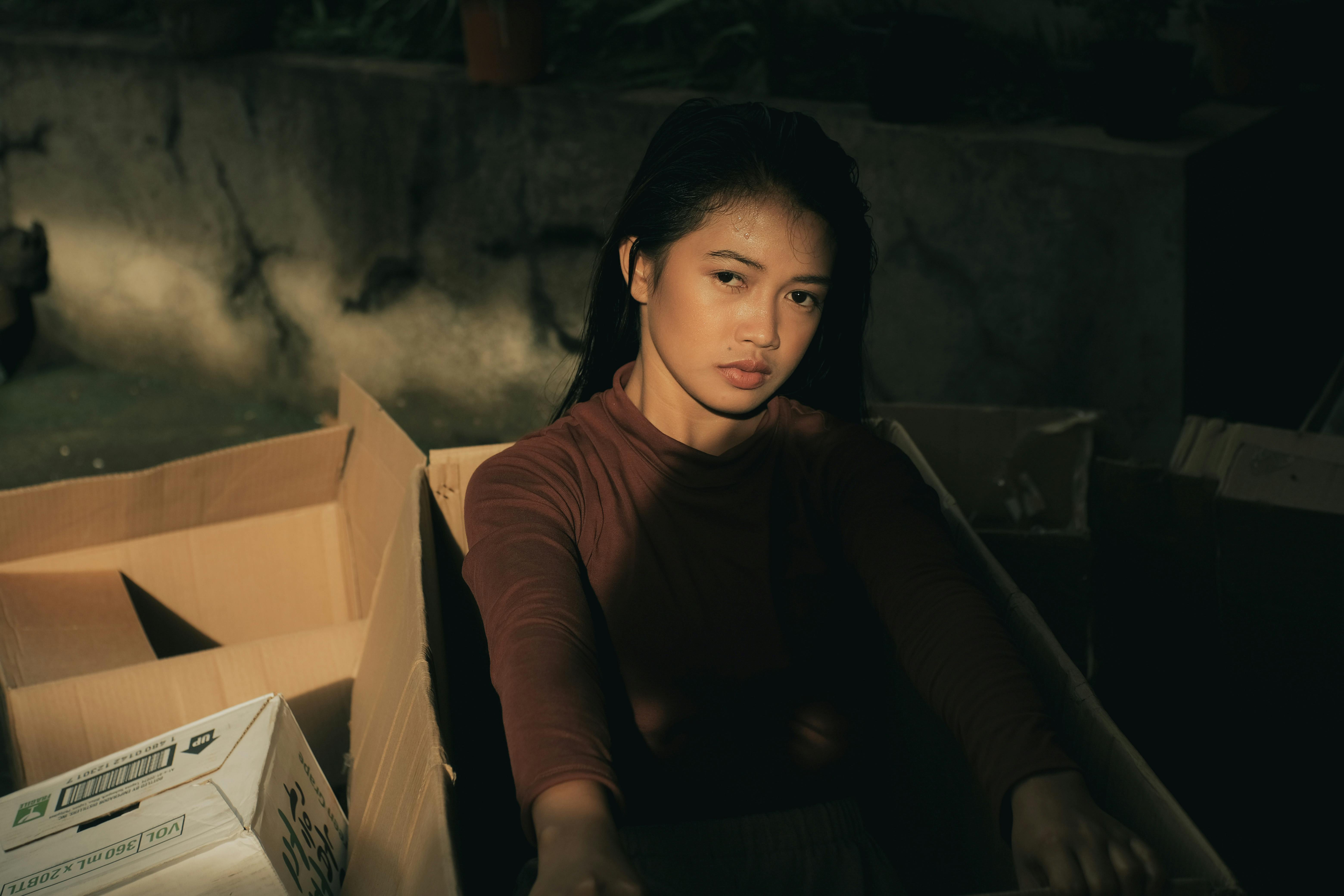 Anonymous person with box on head near carton boxes · Free Stock Photo