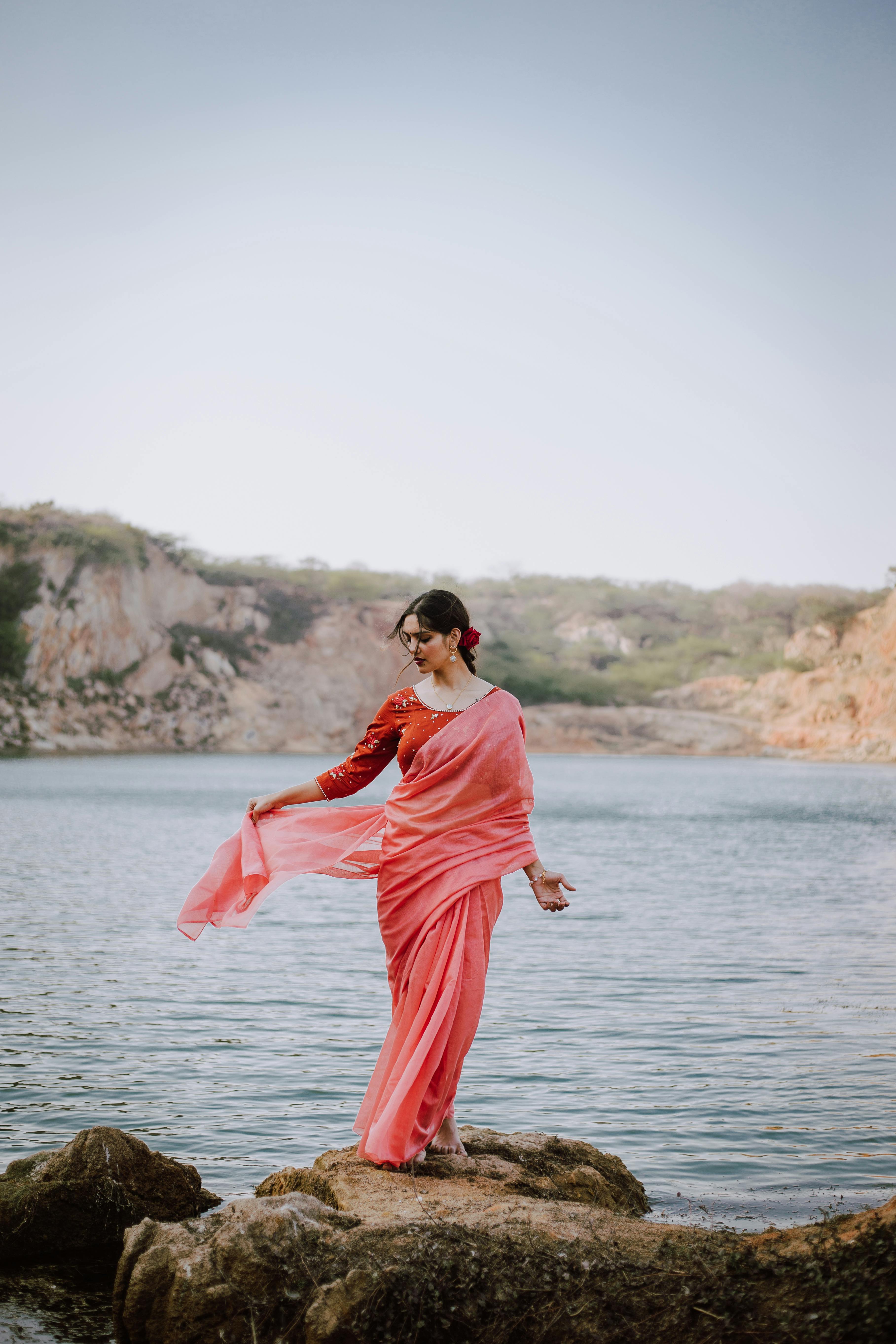 Elegant ethnic woman wearing silk sari standing on river shore · Free ...