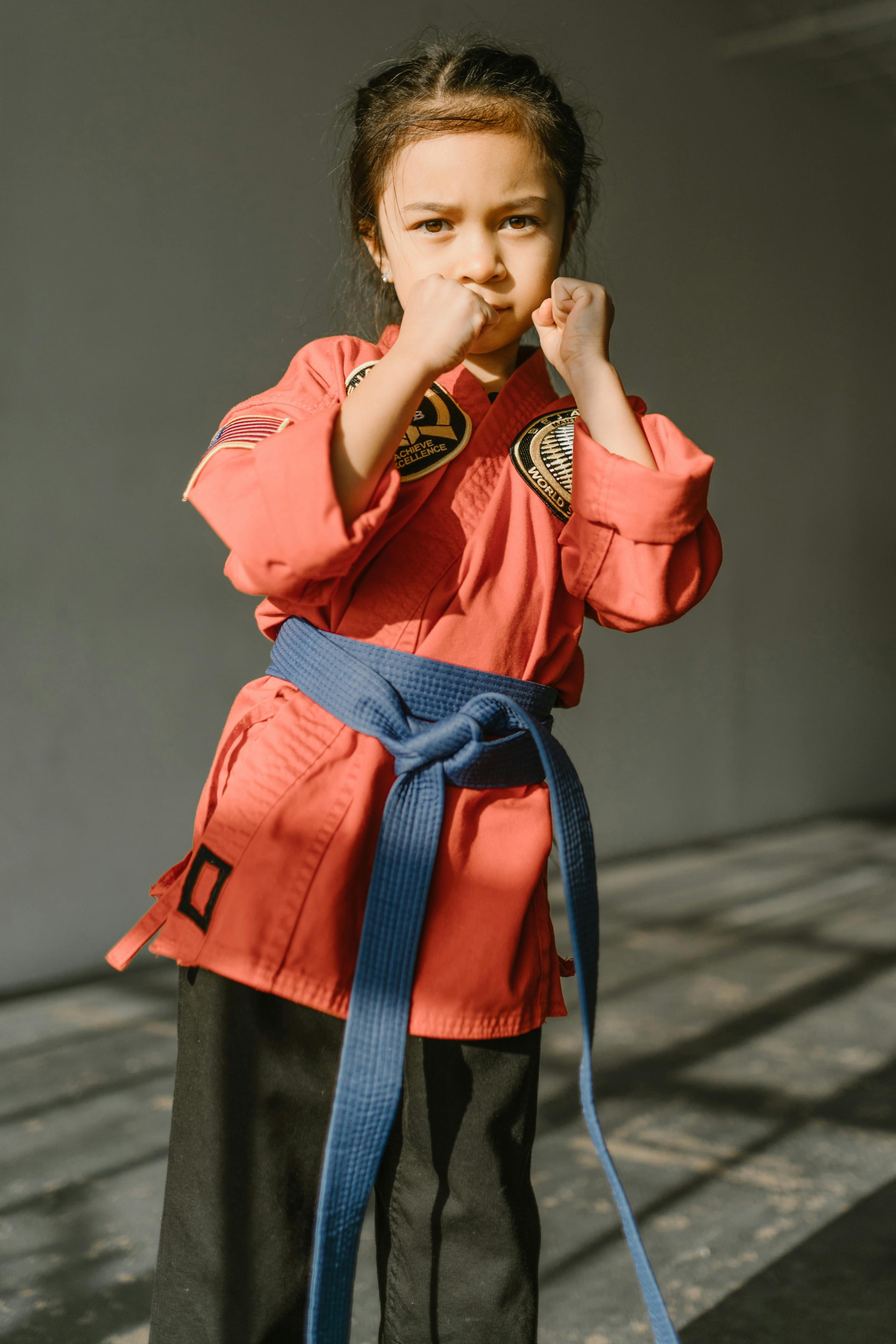 Close-Up Shot of a Girl Wearing Red Dobok and Blue Belt · Free Stock Photo