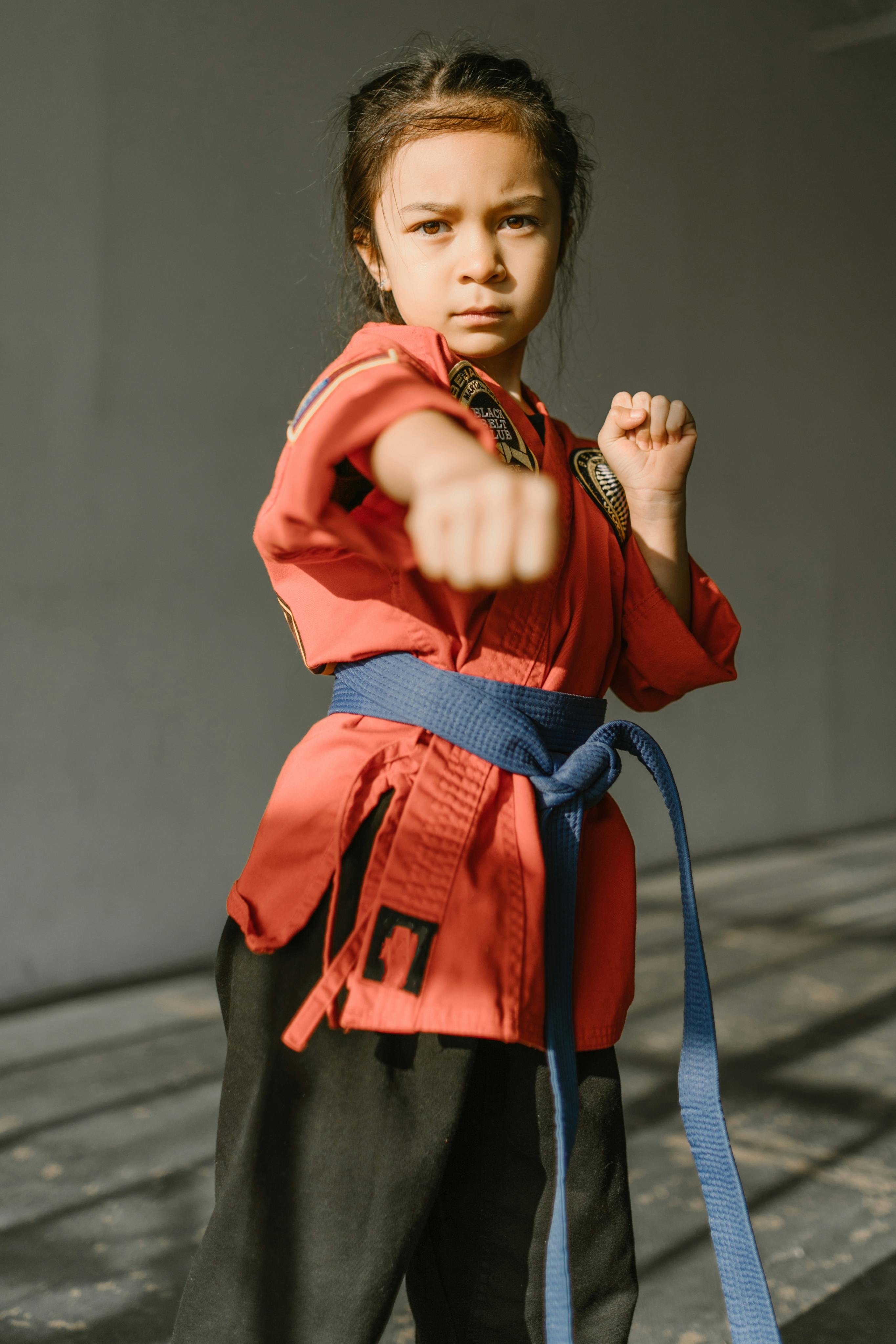 Close-Up Shot of a Girl Wearing Red Dobok and Blue Belt · Free Stock Photo