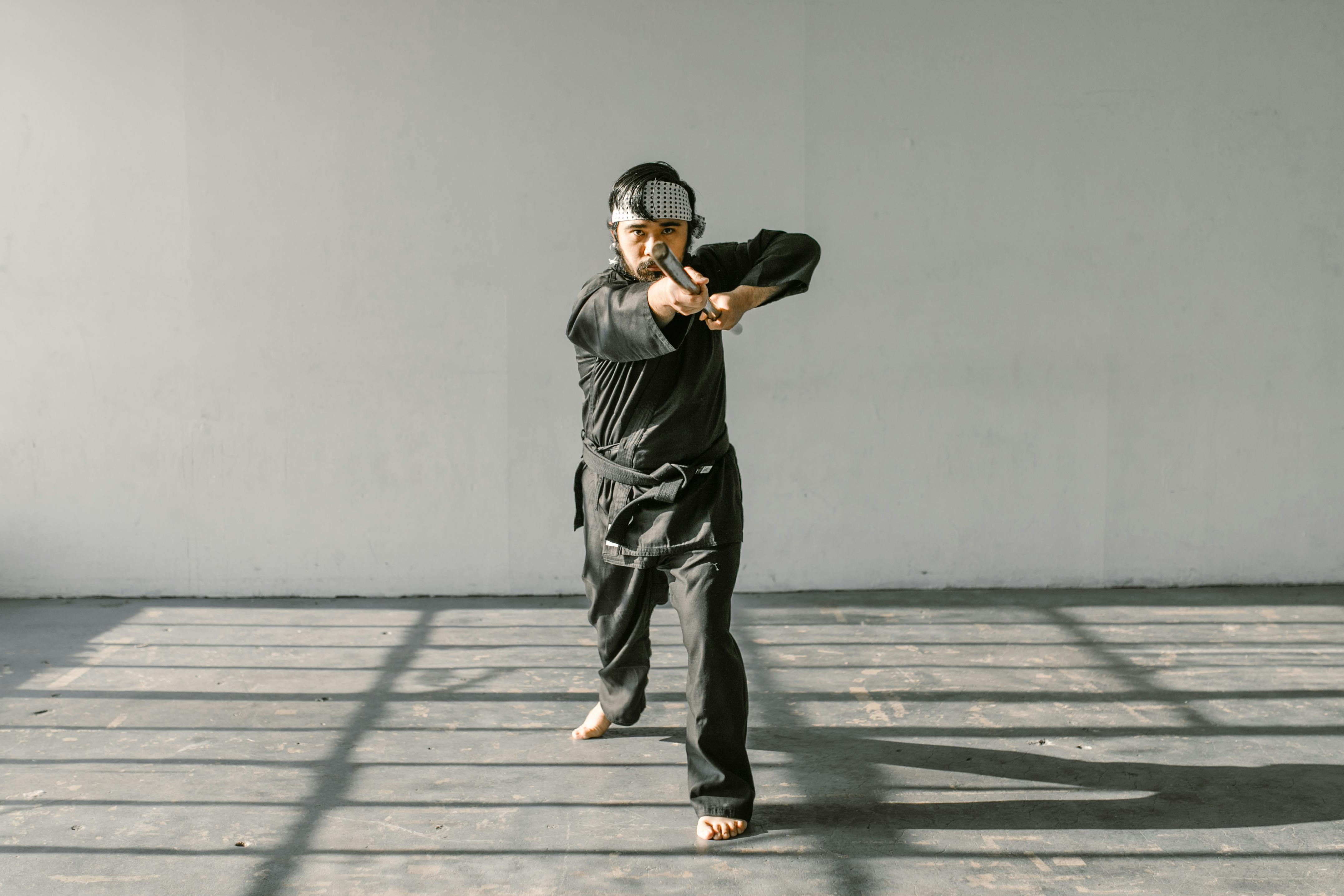 Man in Black Karate Uniform Holding a Stick · Free Stock Photo