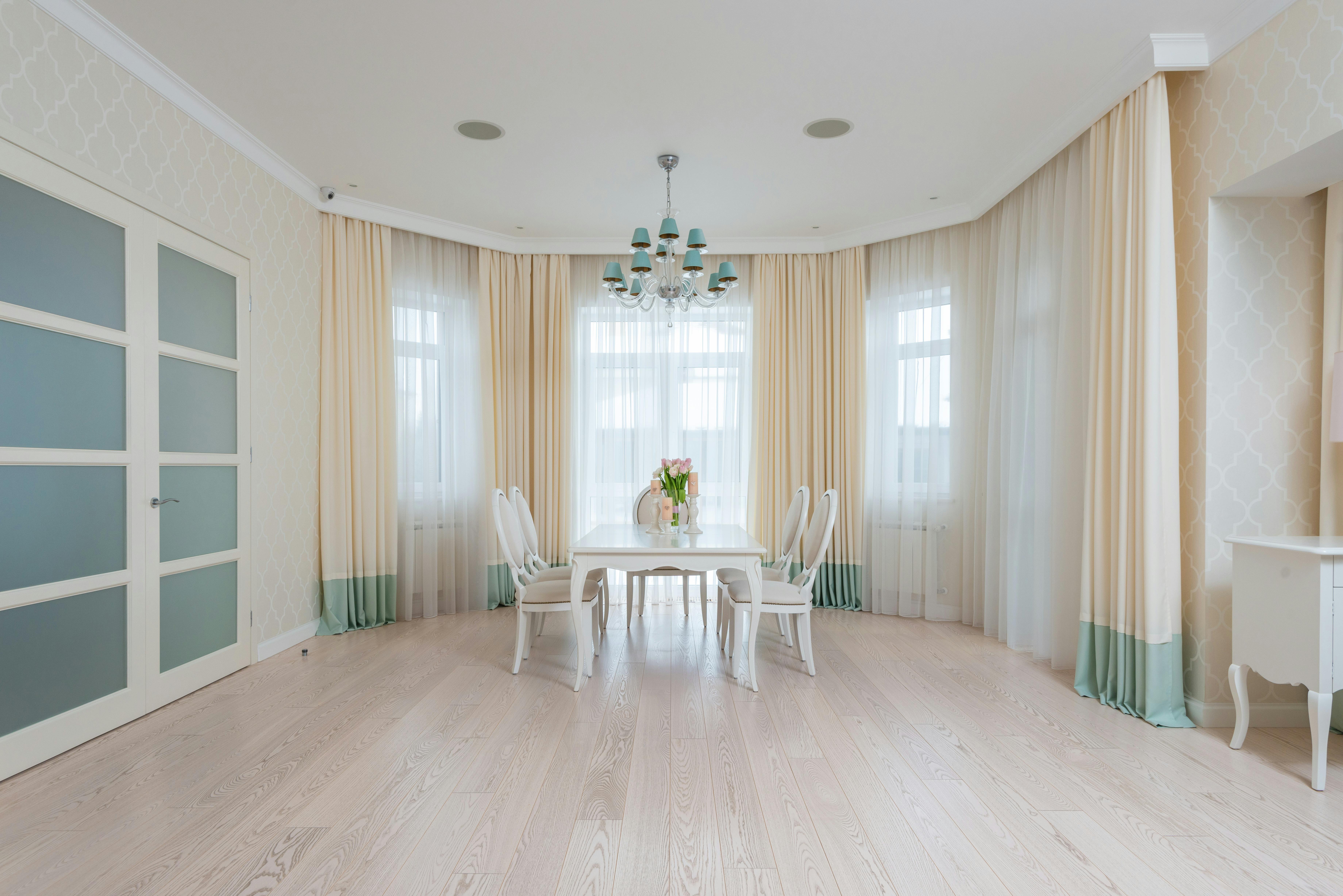 Dining table with chairs in room near windows with curtains · Free ...