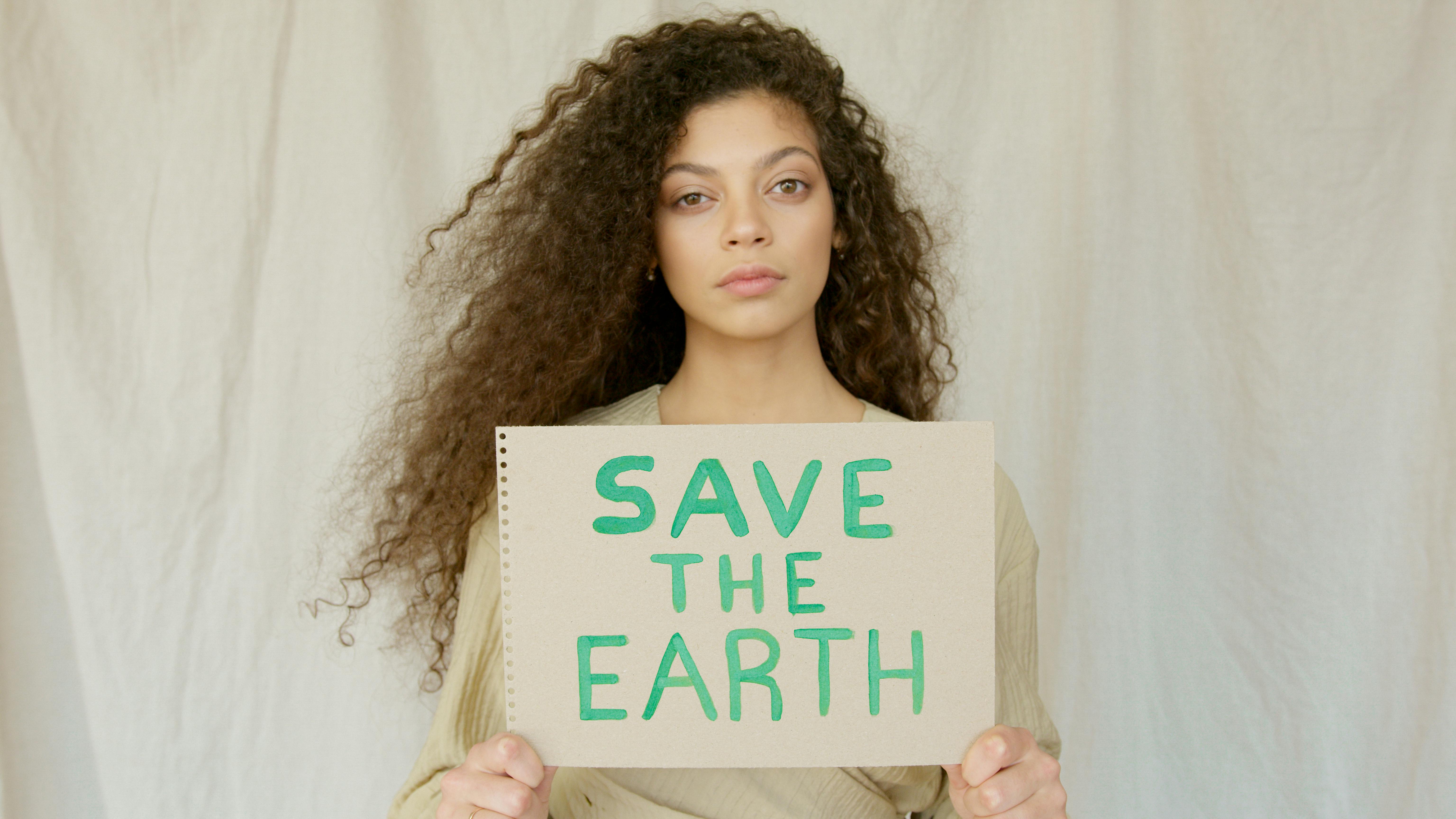 Woman Holding Save the Earth Sign · Free Stock Photo