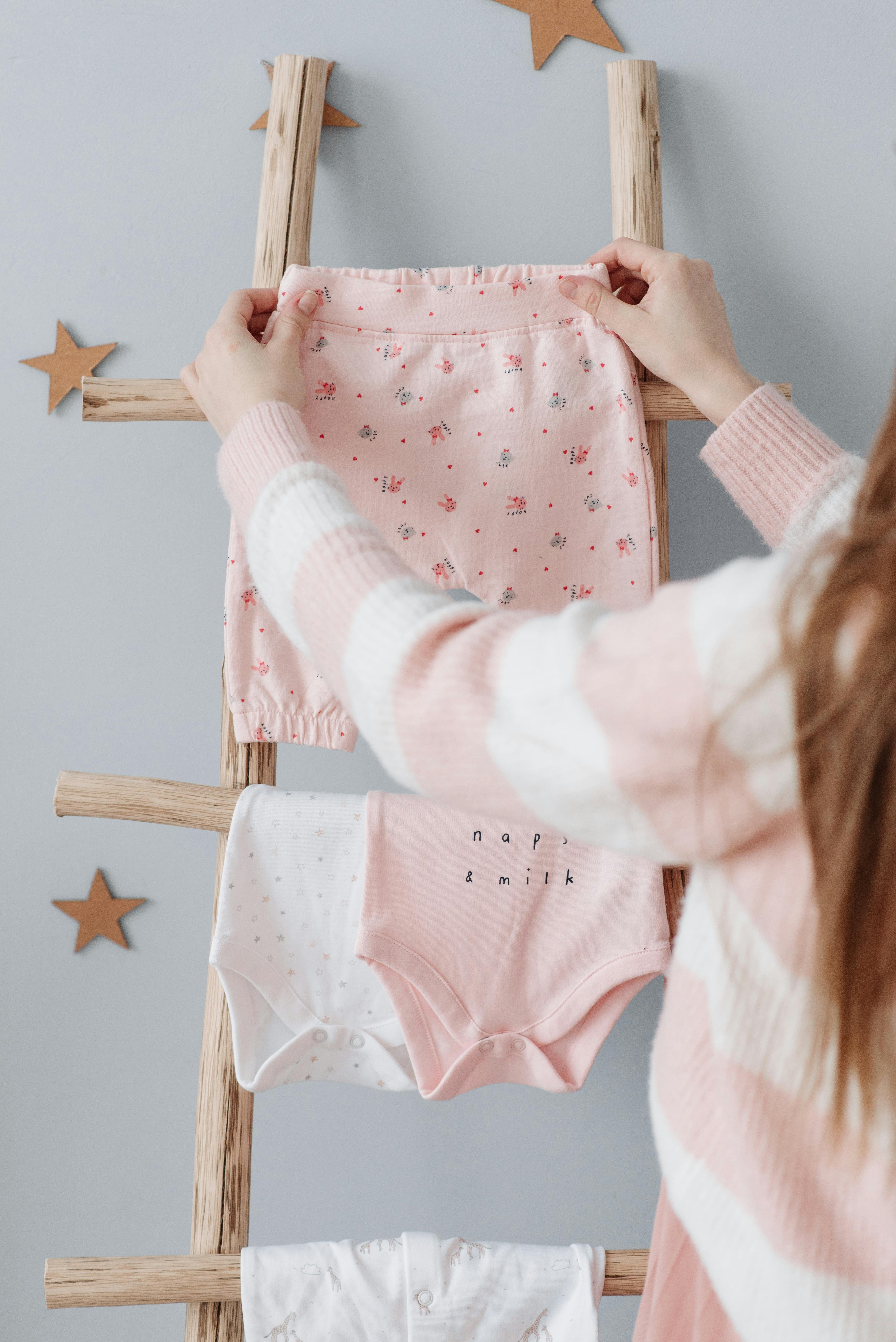 Woman Hanging Baby Clothes on a Ladder · Free Stock Photo