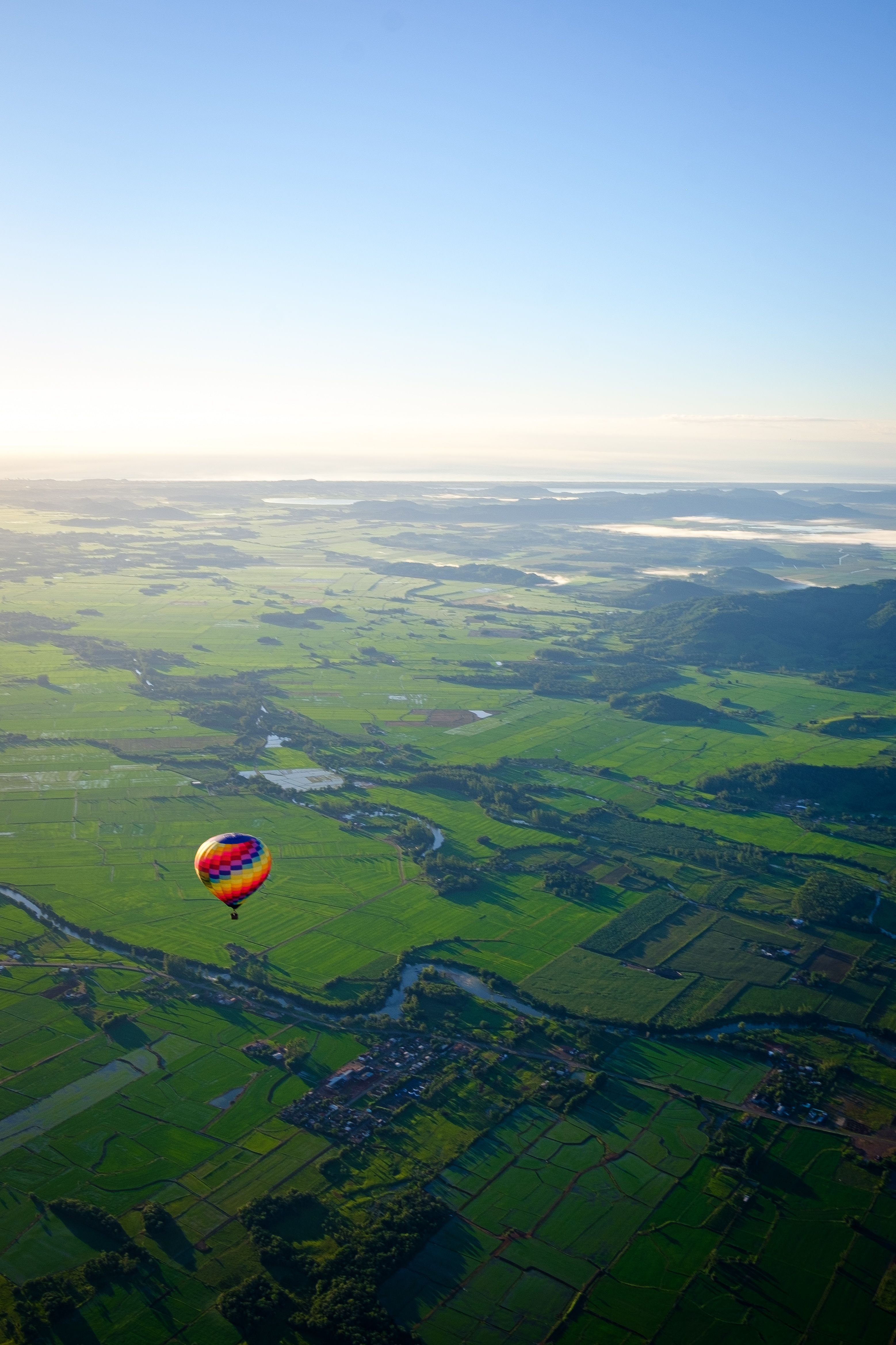 Aerial View of a Hot Air Balloon Flying Over Croplands · Free Stock Photo
