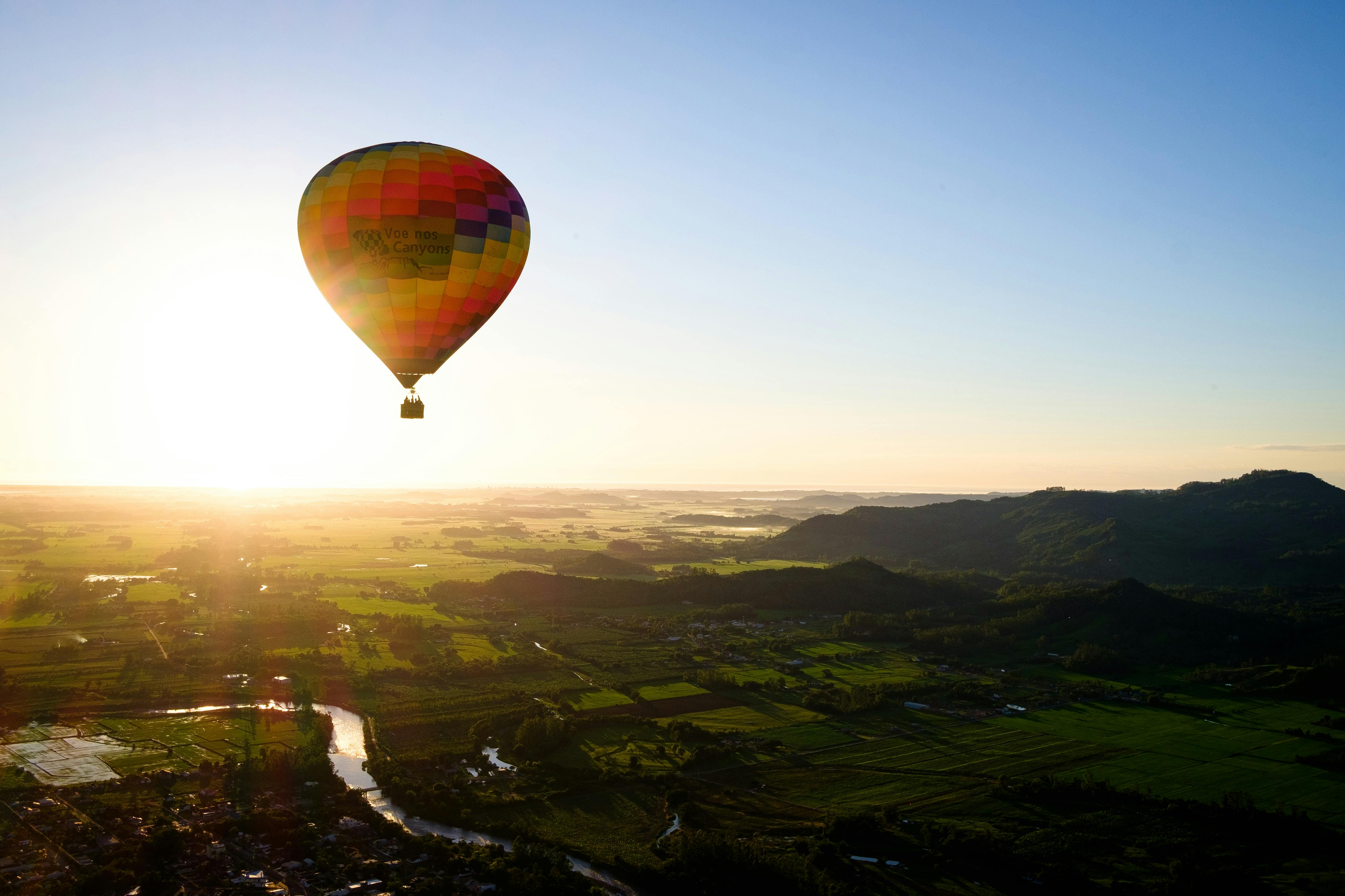 A Hot Air Balloon Flying Over a Countryside · Free Stock Photo