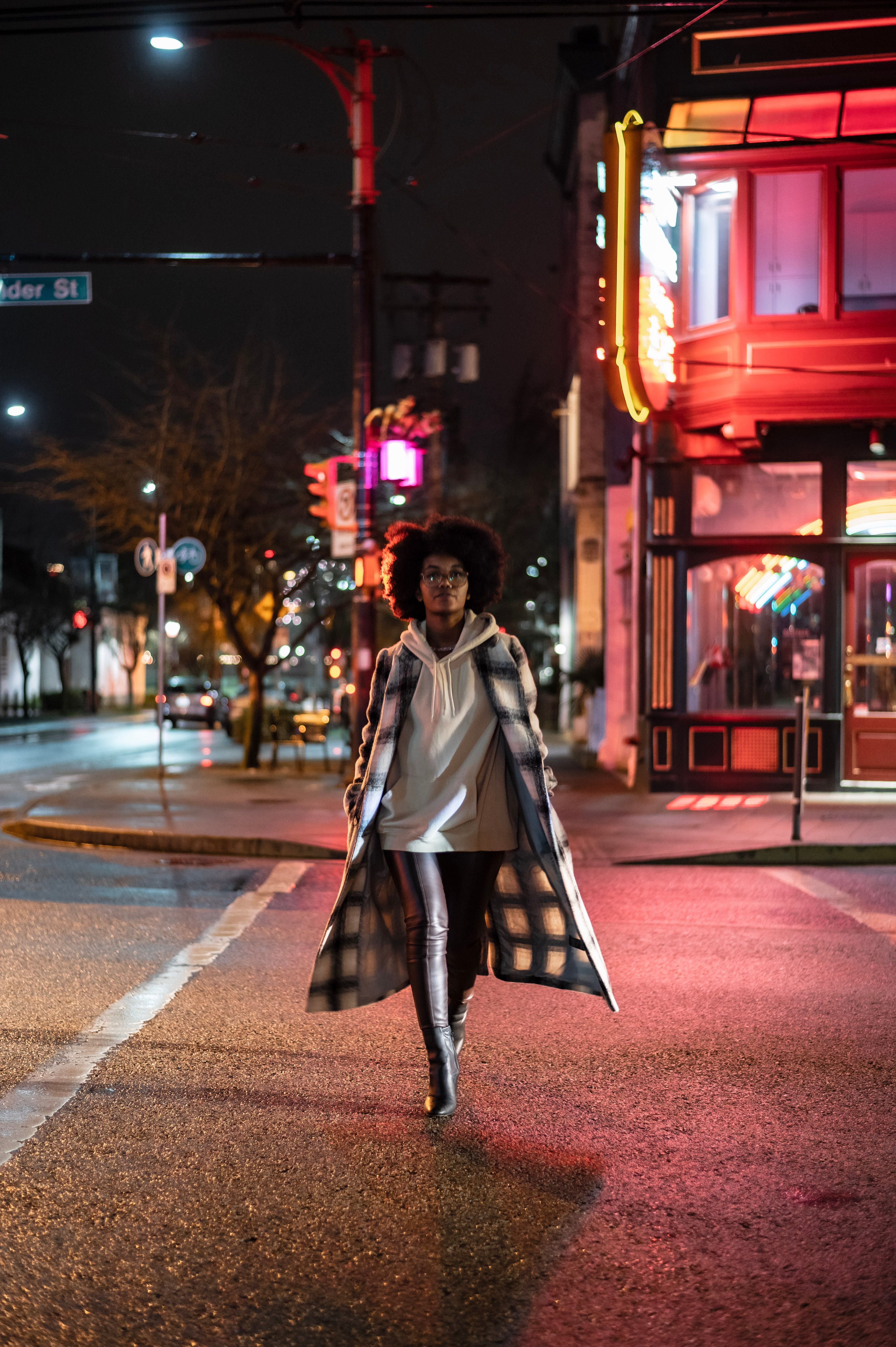 Stylish woman crossing road on city street with lights · Free Stock Photo