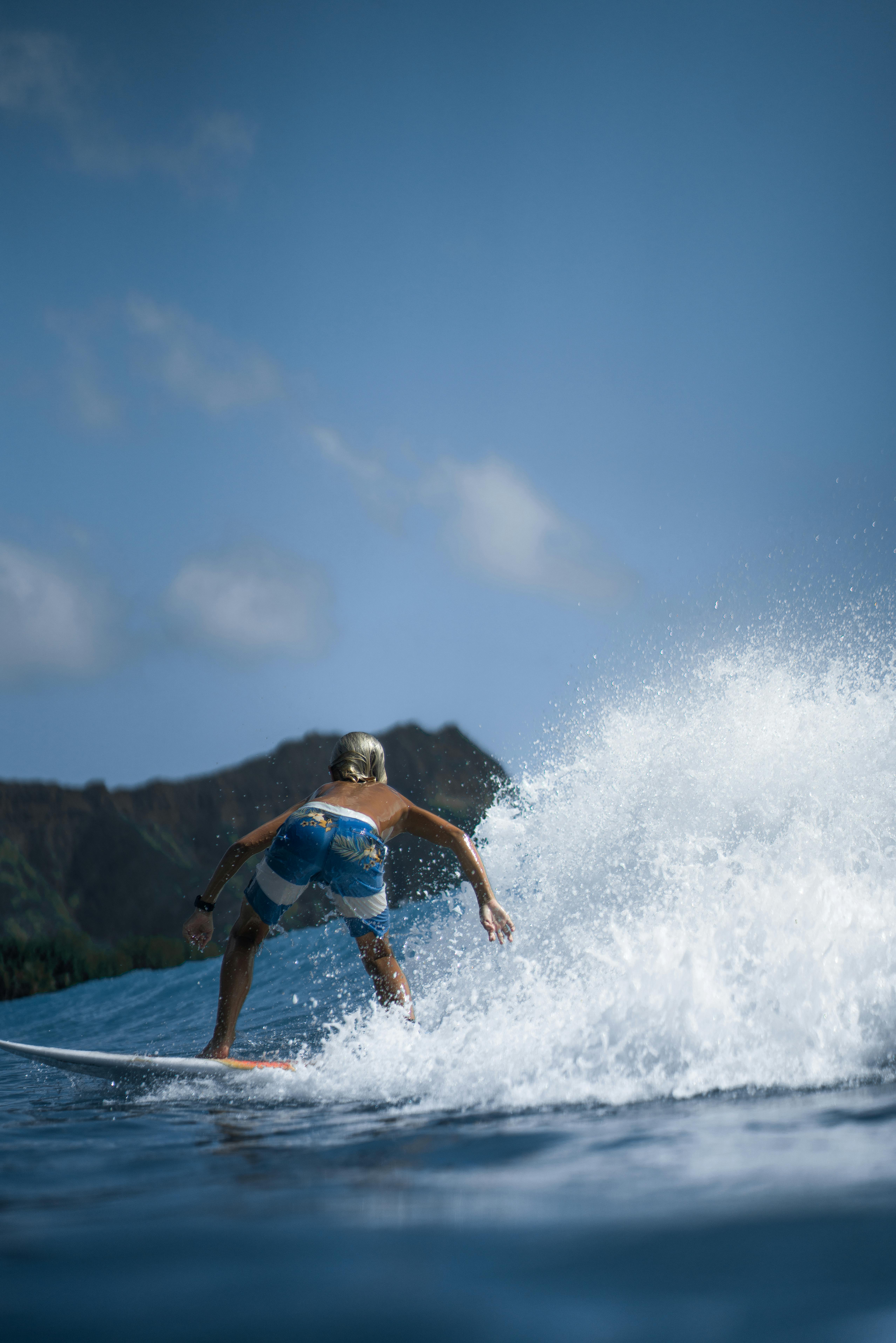 Man riding surfboard in wavy ocean · Free Stock Photo