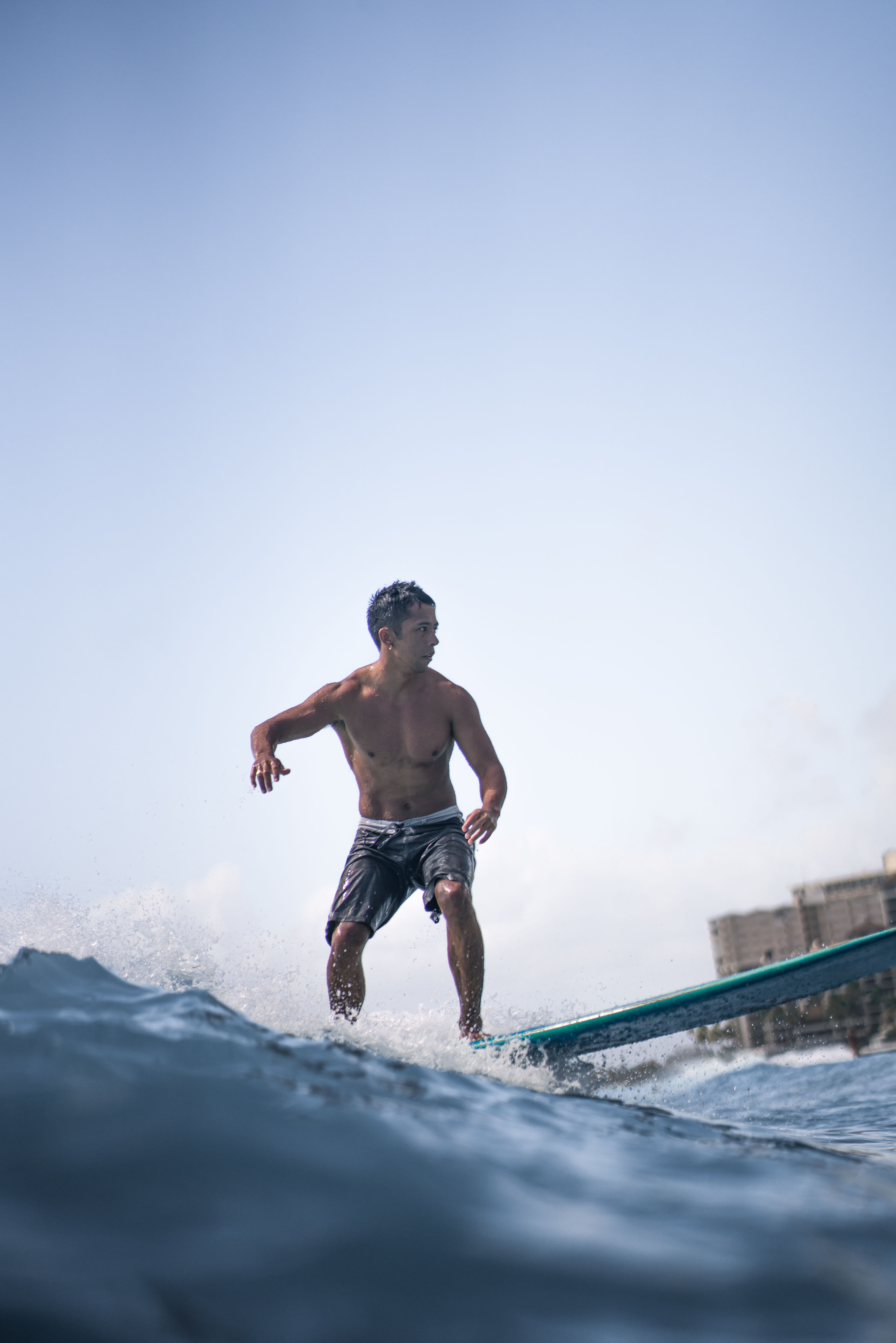 Woman splashing water on surfboard near resort · Free Stock Photo