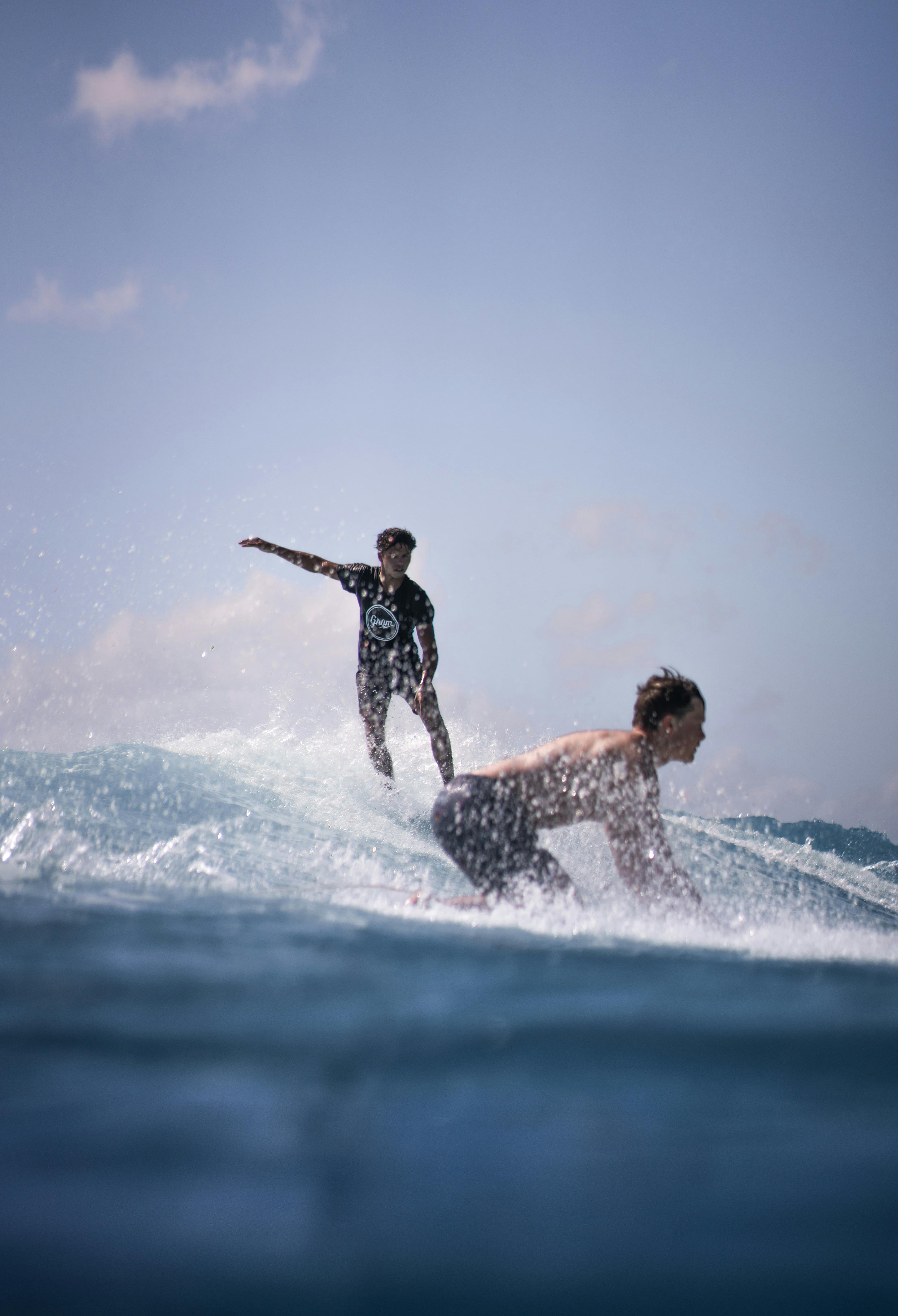 Man riding surfboard in wavy ocean · Free Stock Photo