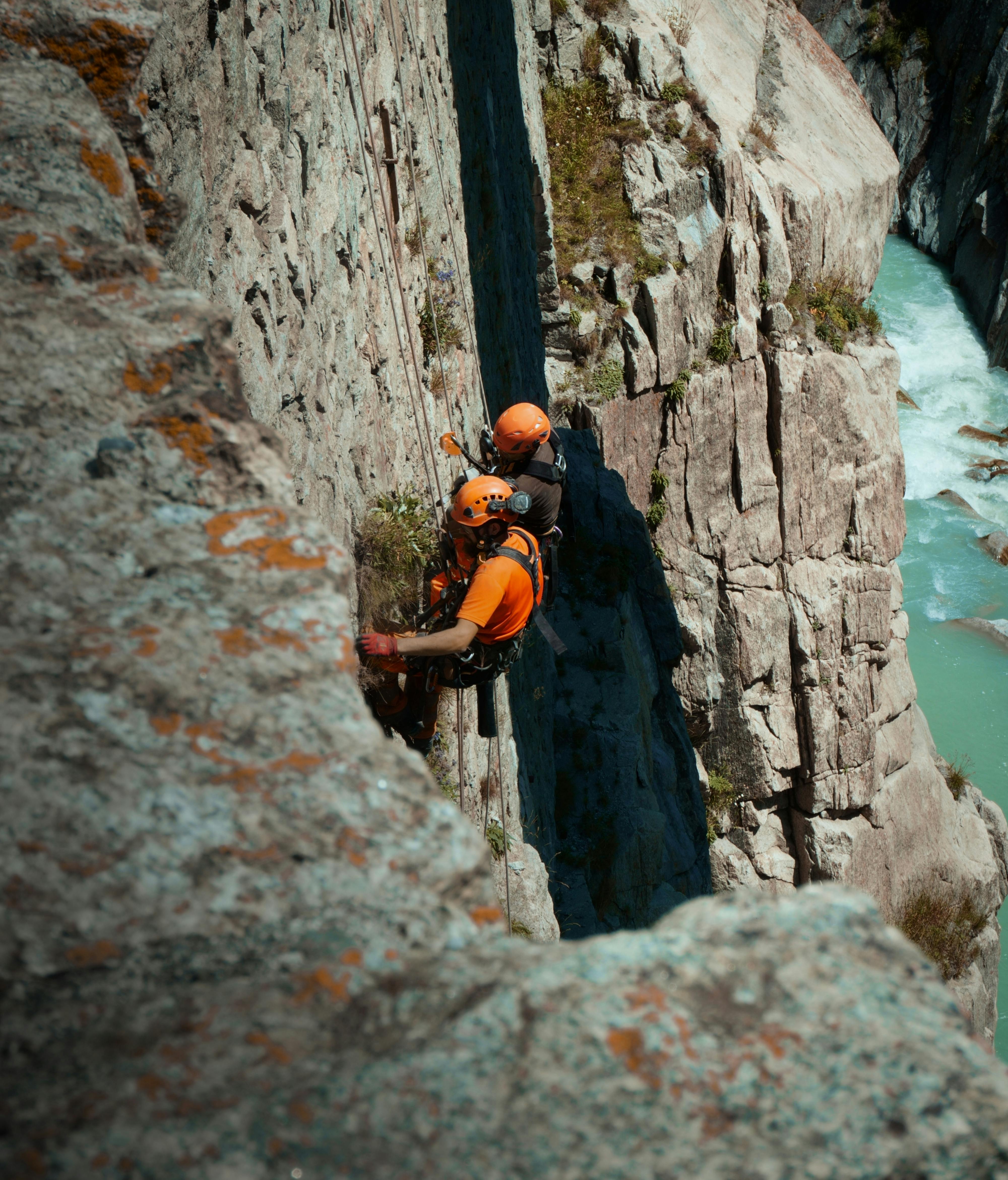 Man Carrying a Backpack Climbing a Mountain Cliff · Free Stock Photo