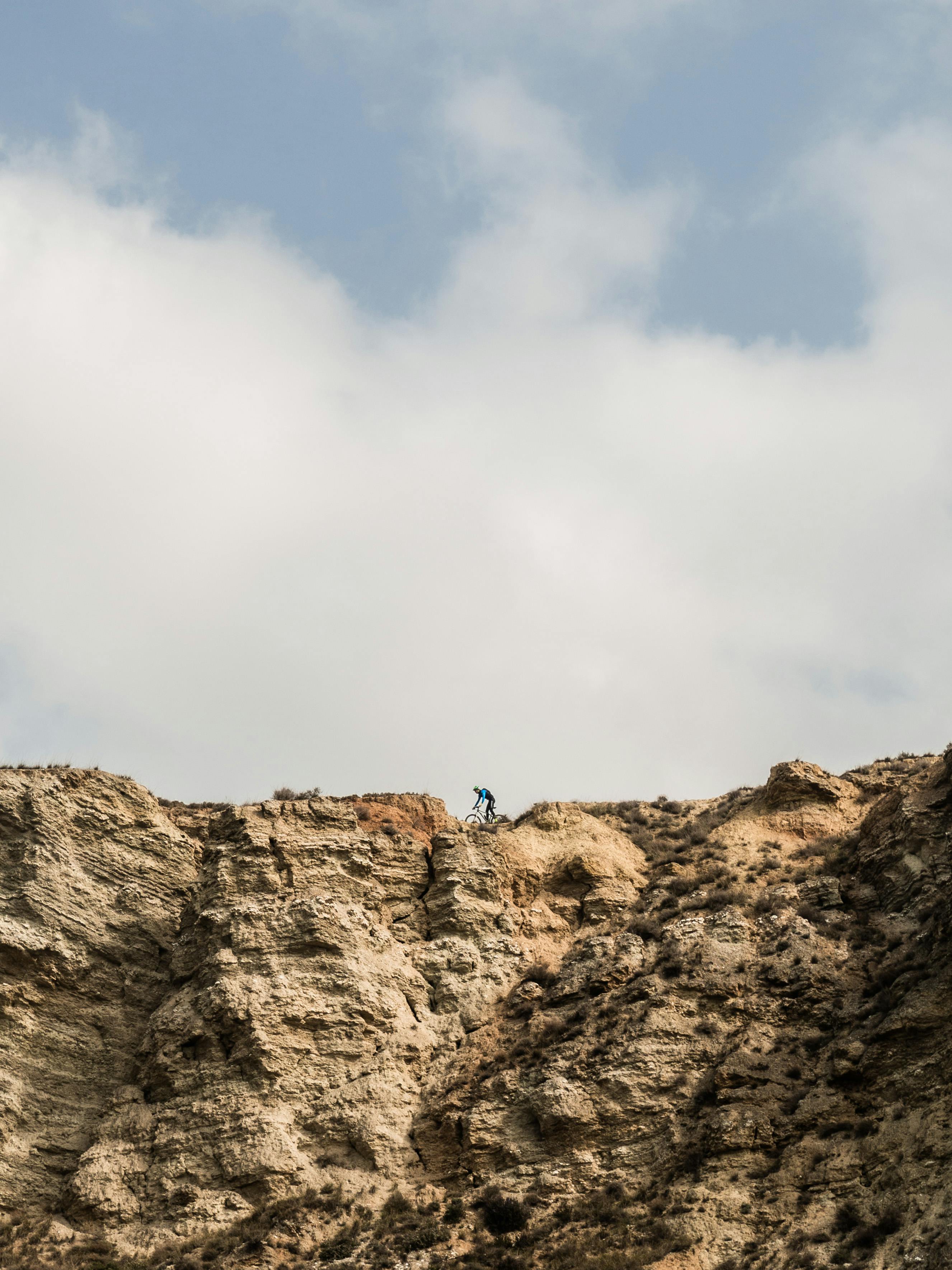 Person Riding a Bicycle on Rocky Mountain · Free Stock Photo