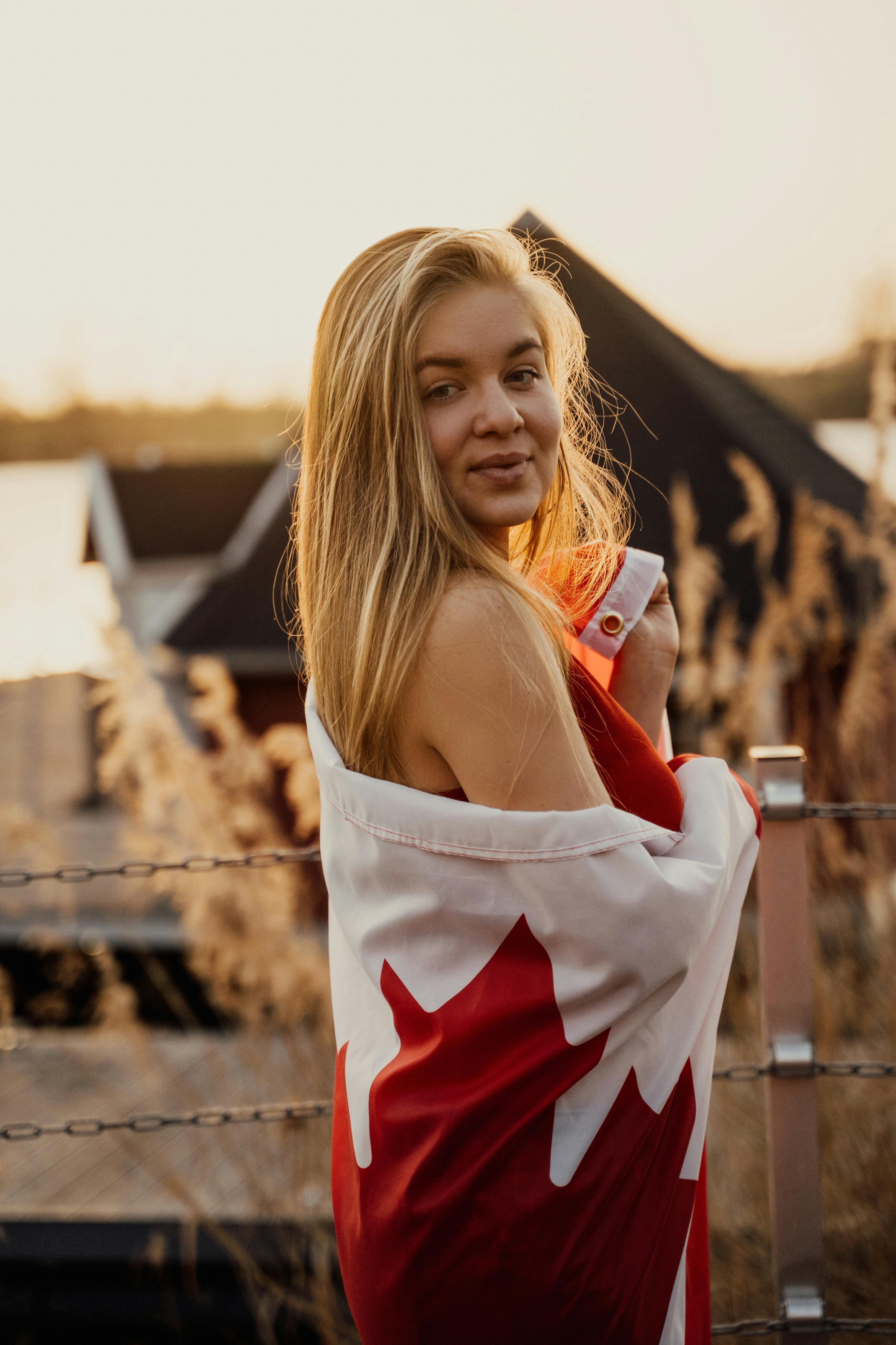 Woman Smiling while Holding a Canadian Flag · Free Stock Photo