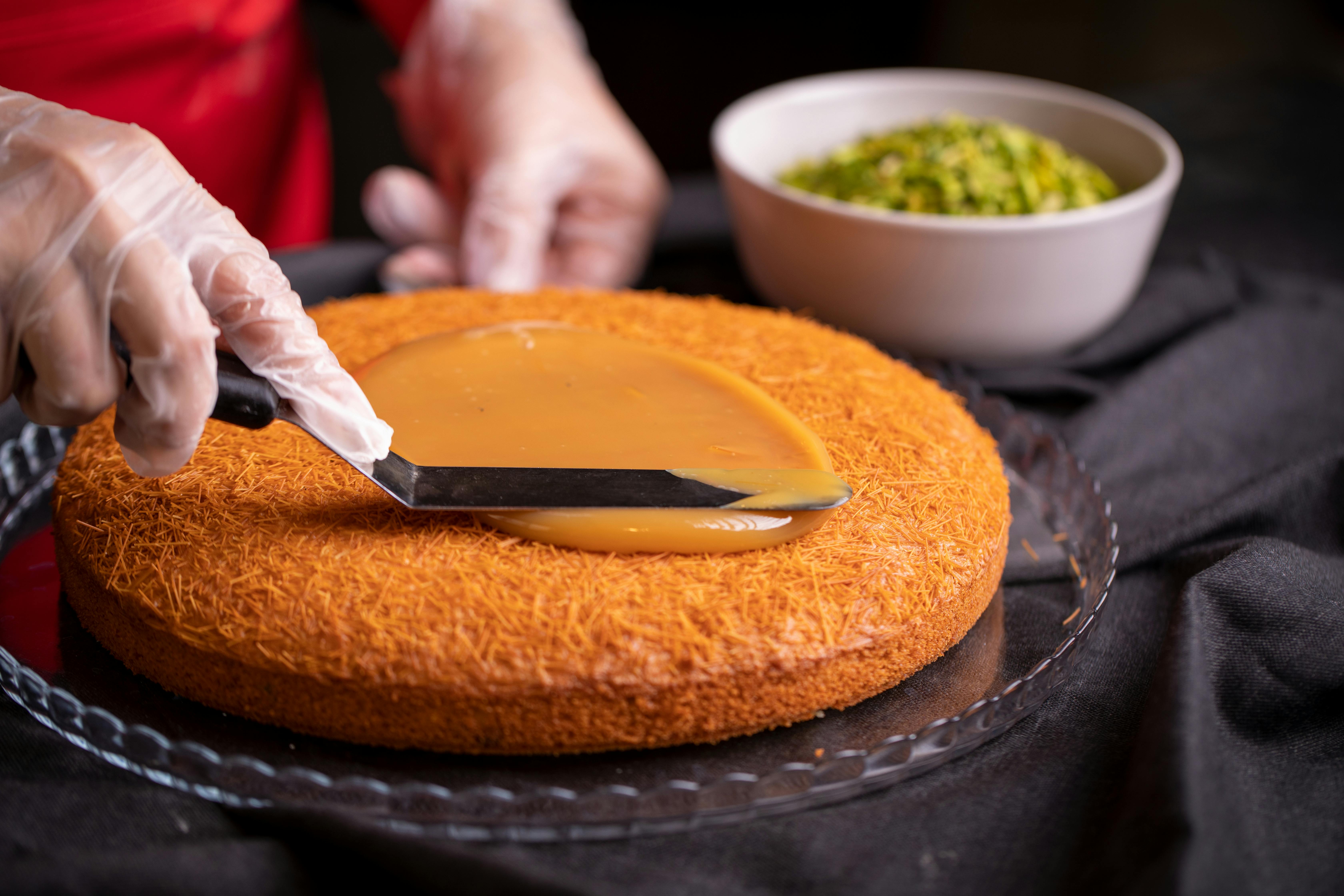 Person Putting Icing on a Cake · Free Stock Photo