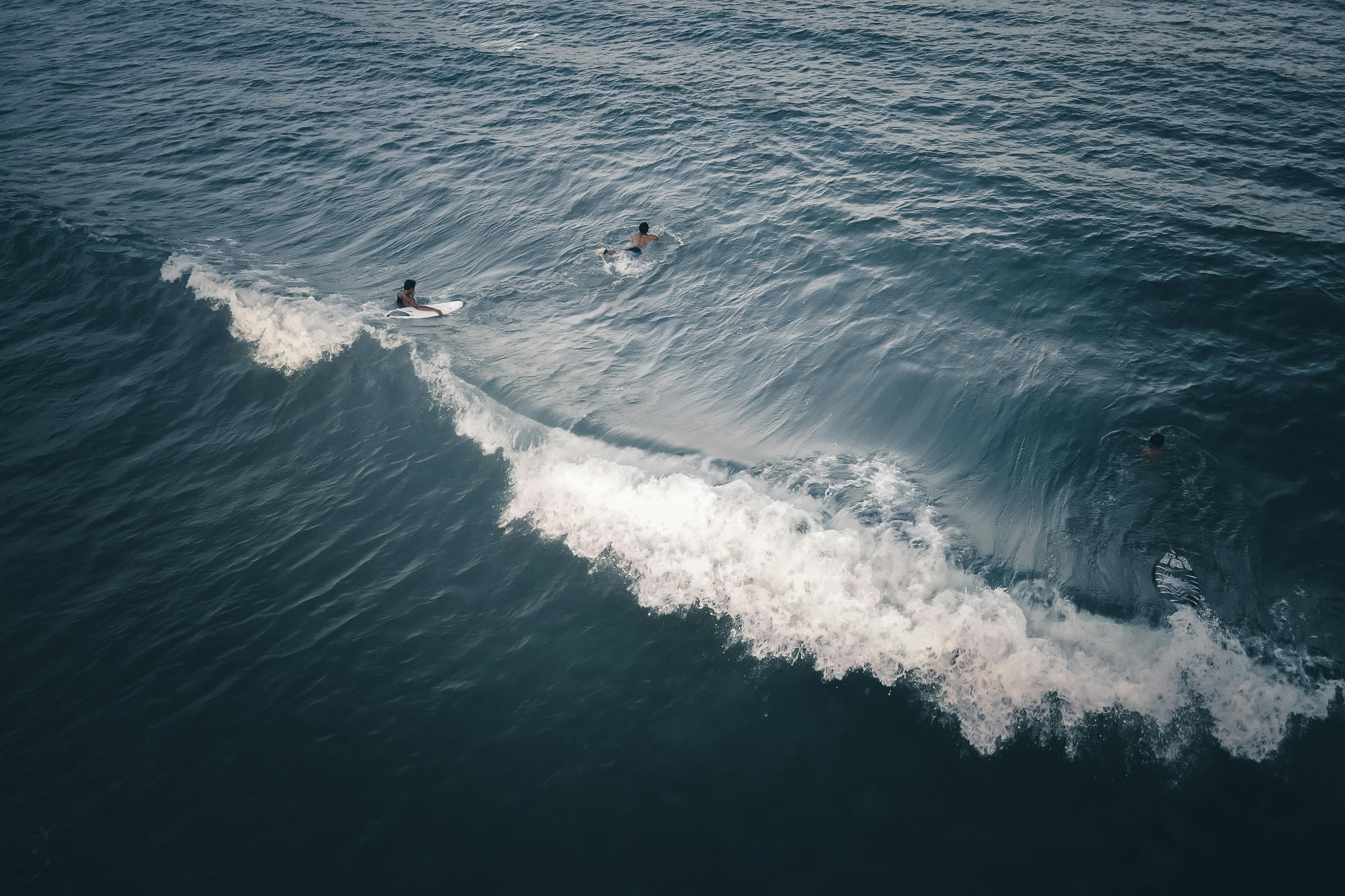 Man riding surfboard in wavy ocean · Free Stock Photo
