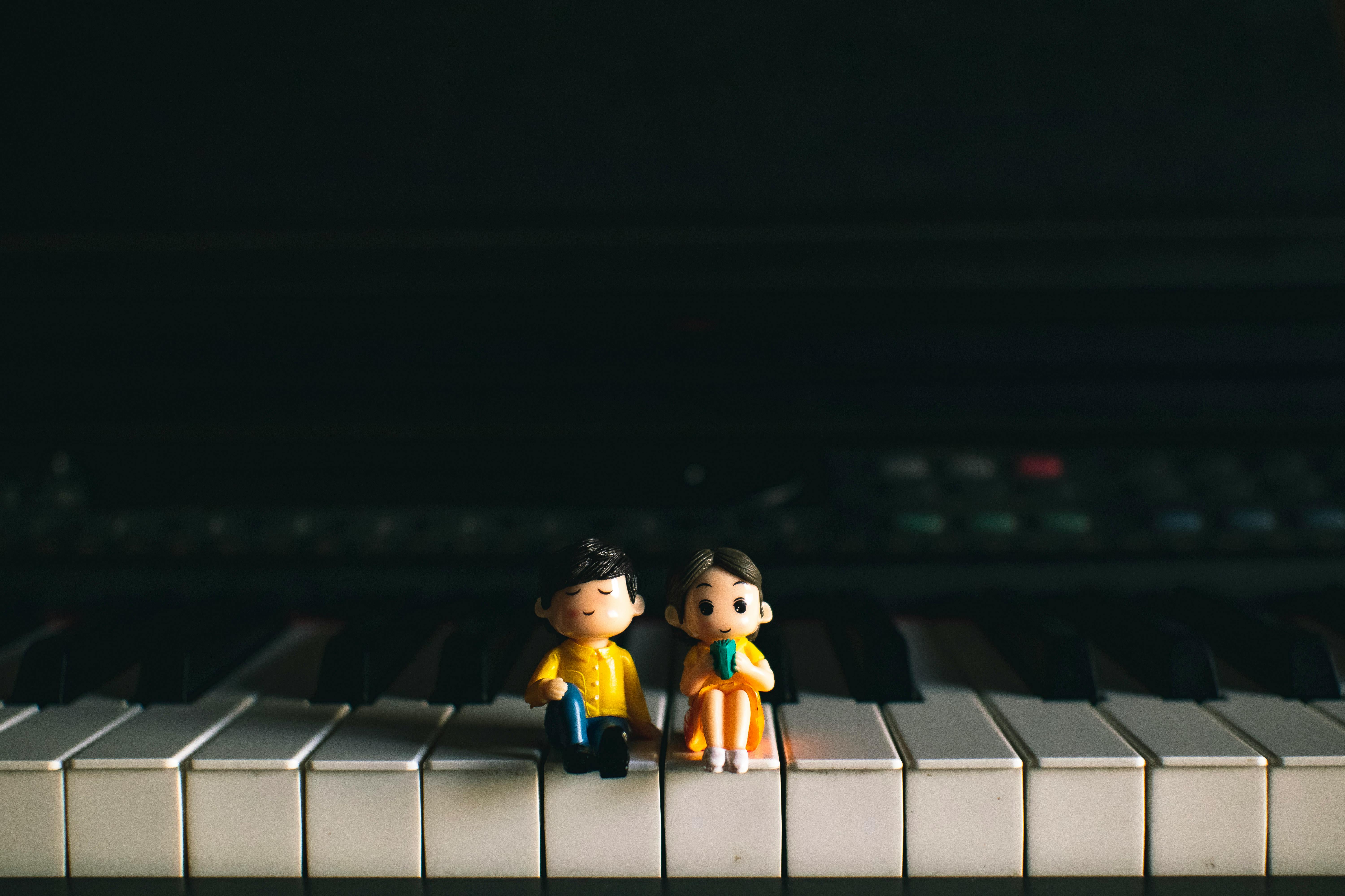 Statuettes of romantic couple on piano keyboard · Free Stock Photo