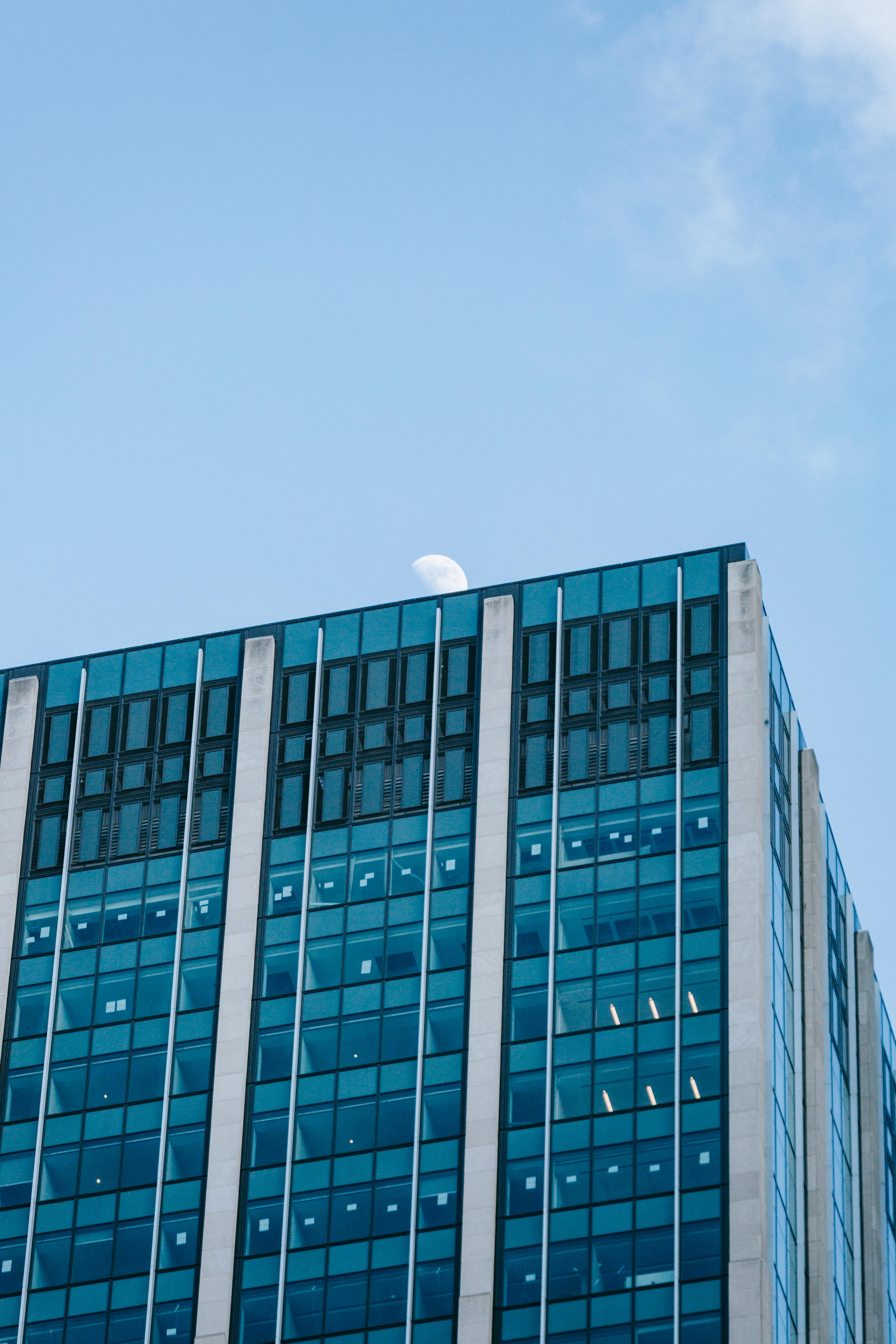 Exterior of modern geometric multistory building under blue sky · Free ...