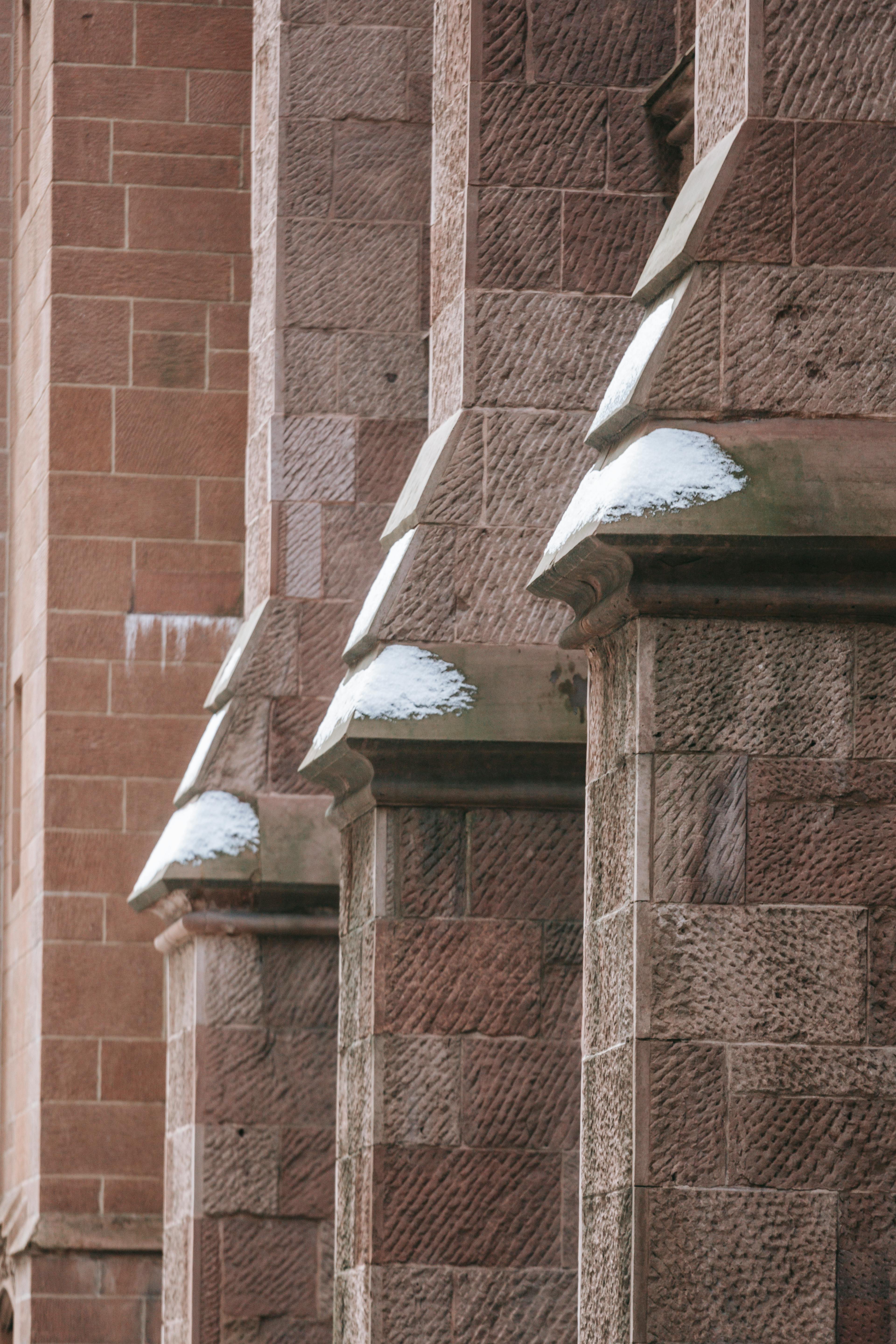 Old stone columns of brick building with snow · Free Stock Photo