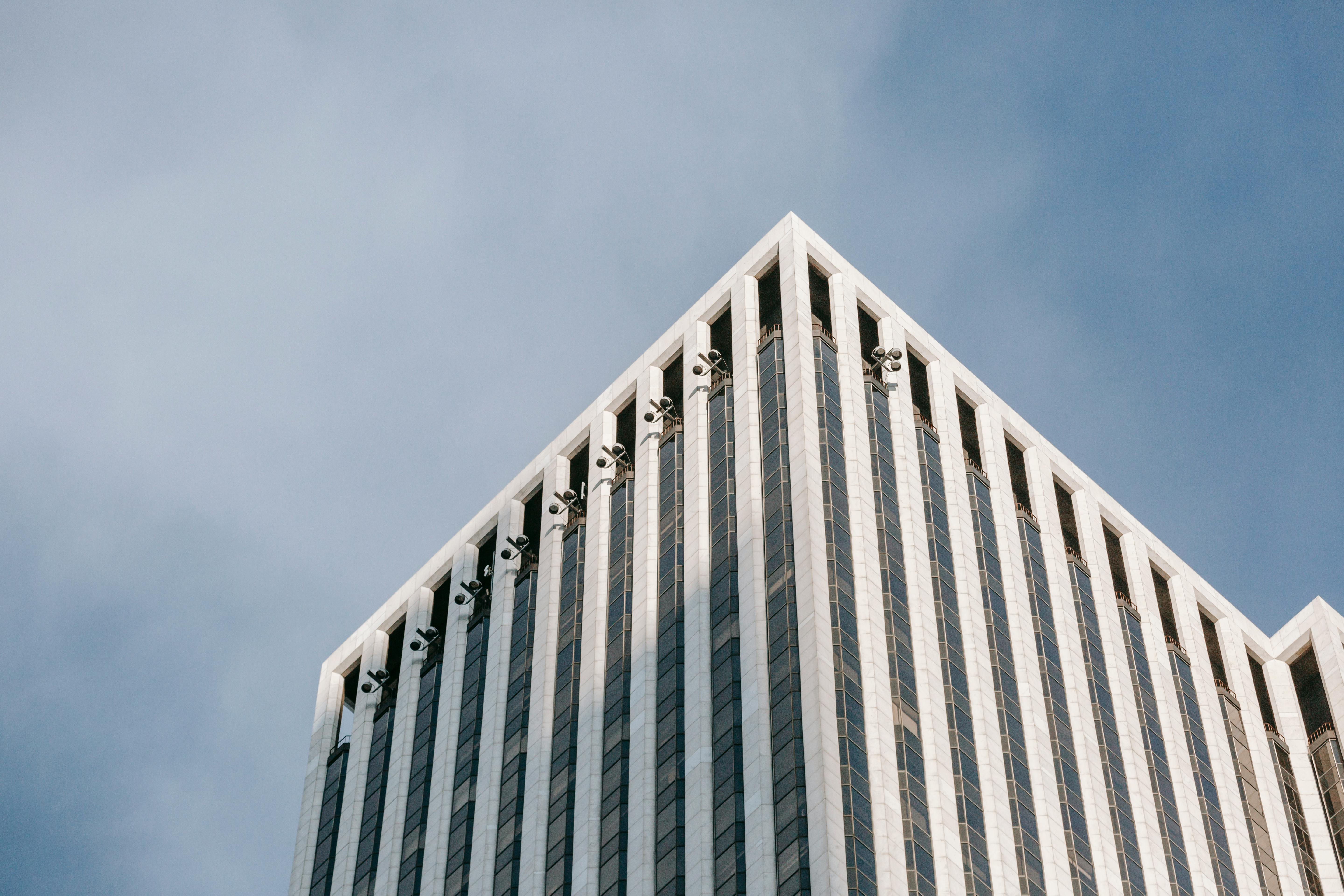 Corner of geometric skyscraper under blue sky · Free Stock Photo