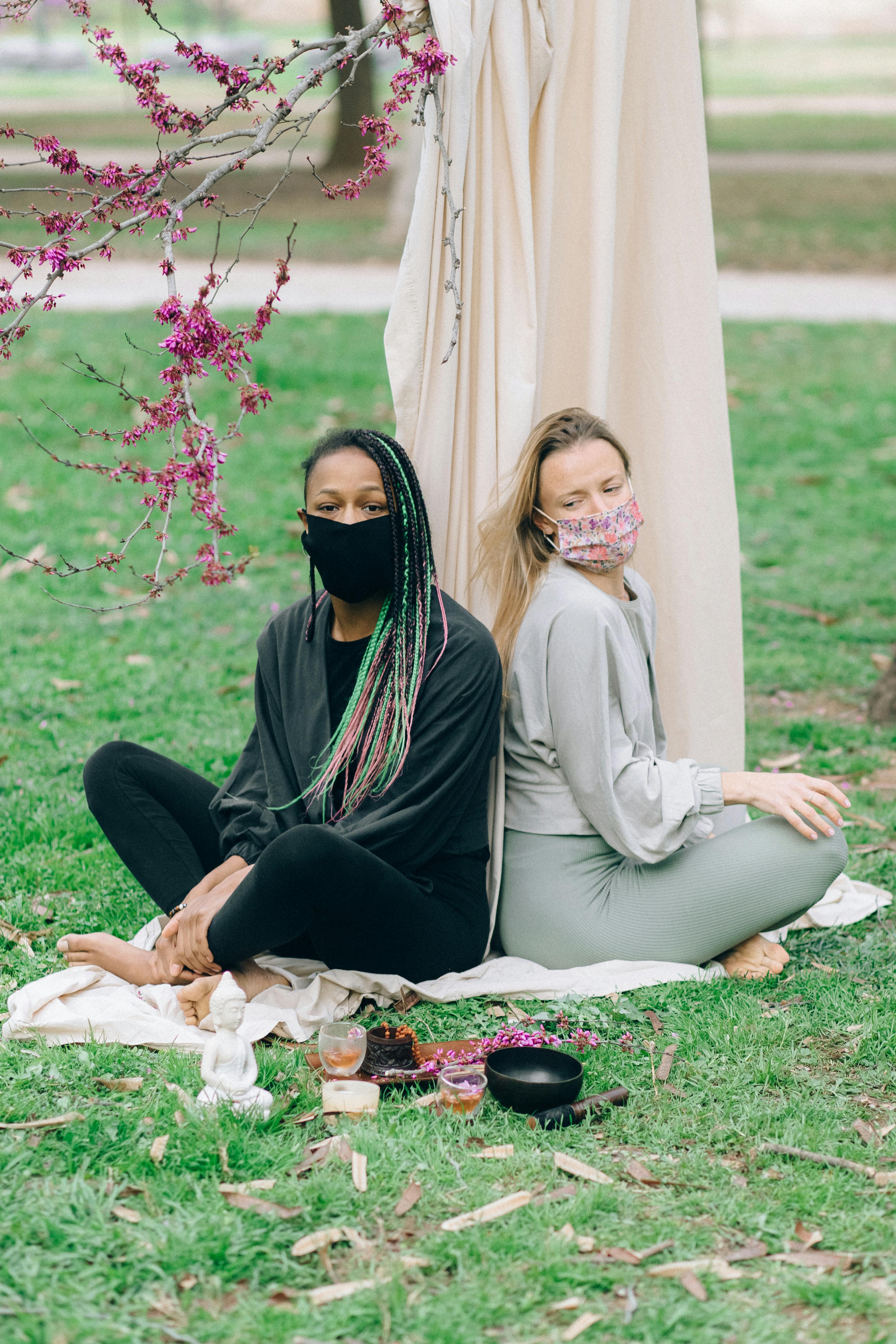 Women with Face Masks Sitting Back to Back · Free Stock Photo