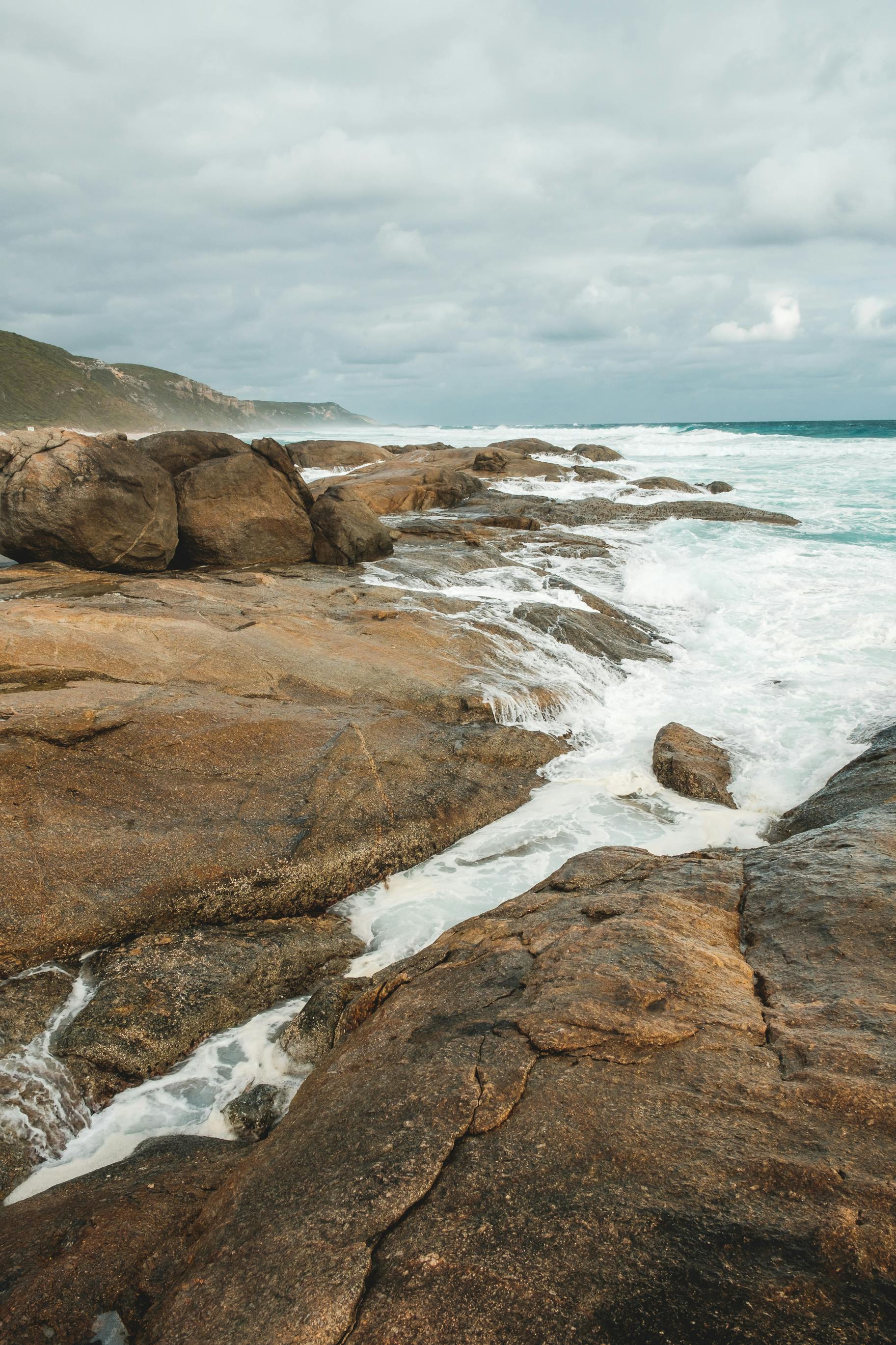 Stony rough seacoast washed by foamy blue sea · Free Stock Photo