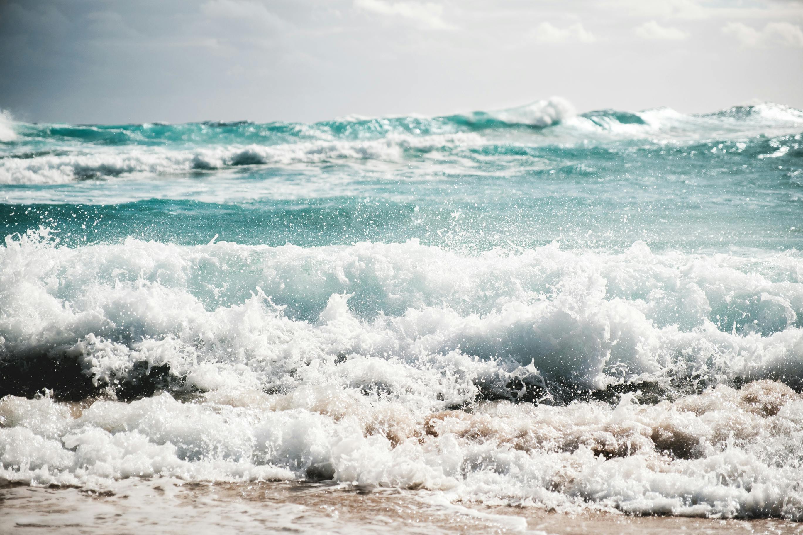Stormy azure sea rolling on sandy shore · Free Stock Photo