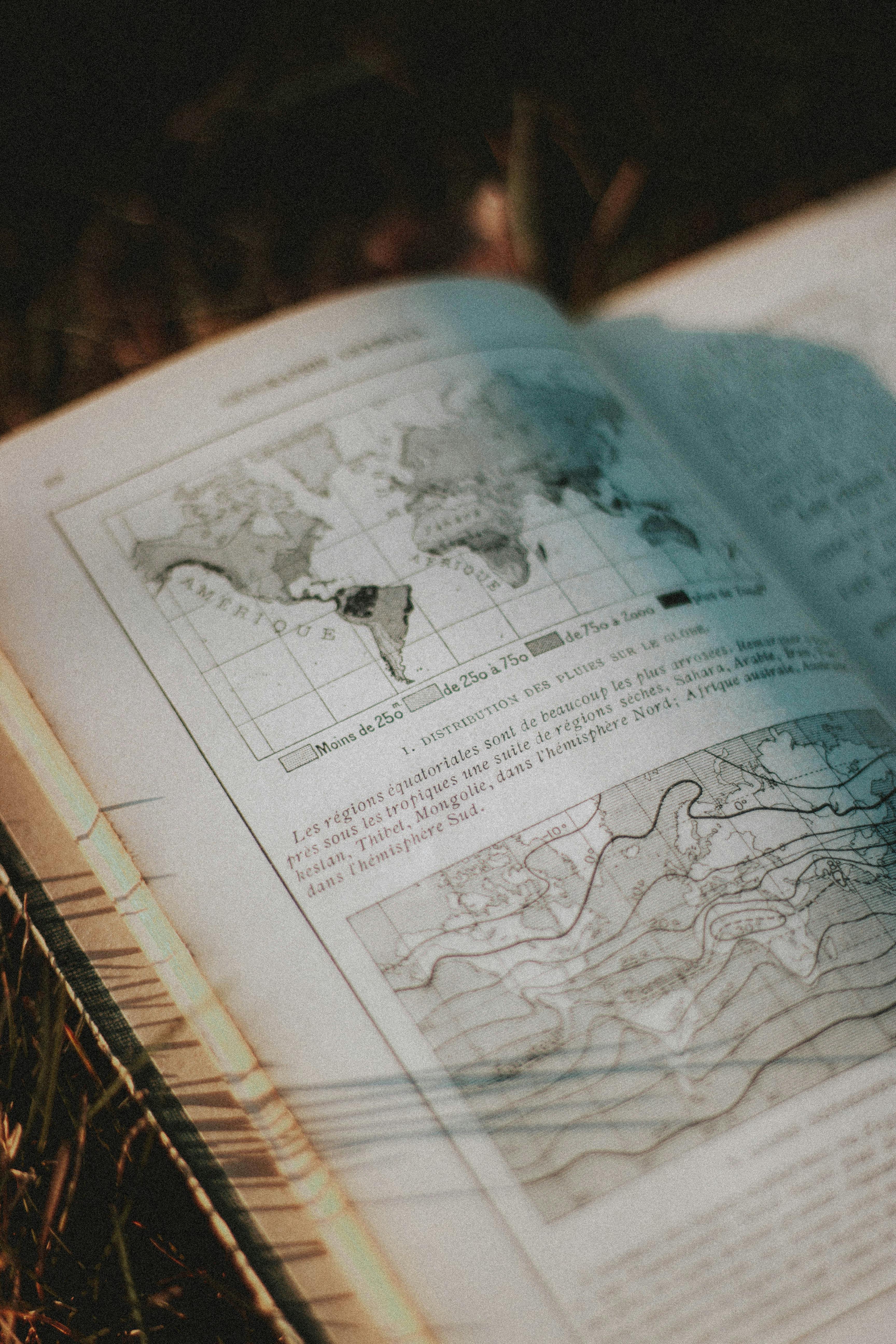 Old book with map illustration in sunlight · Free Stock Photo