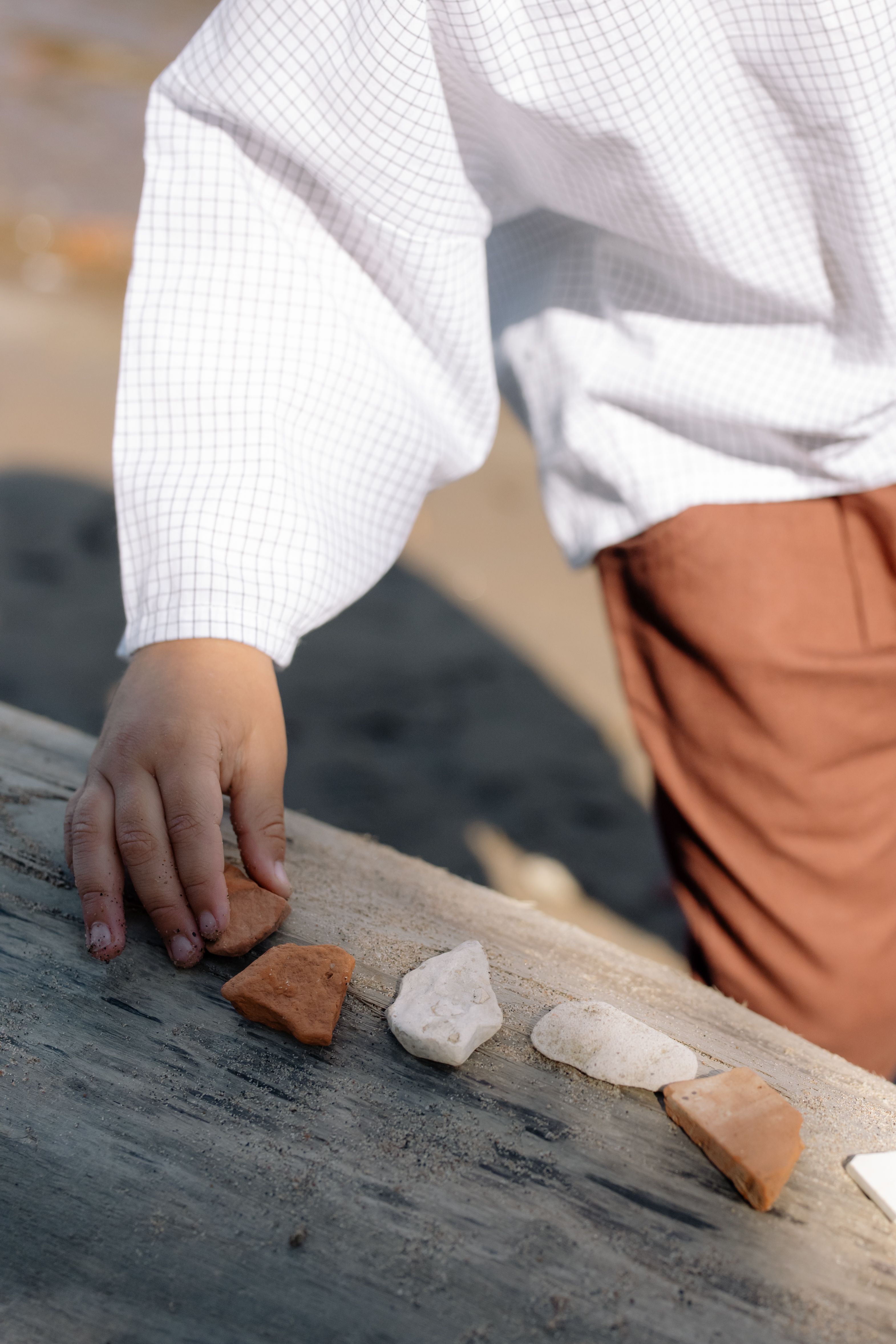 Close-Up Shot of a Child Collecting Stones · Free Stock Photo