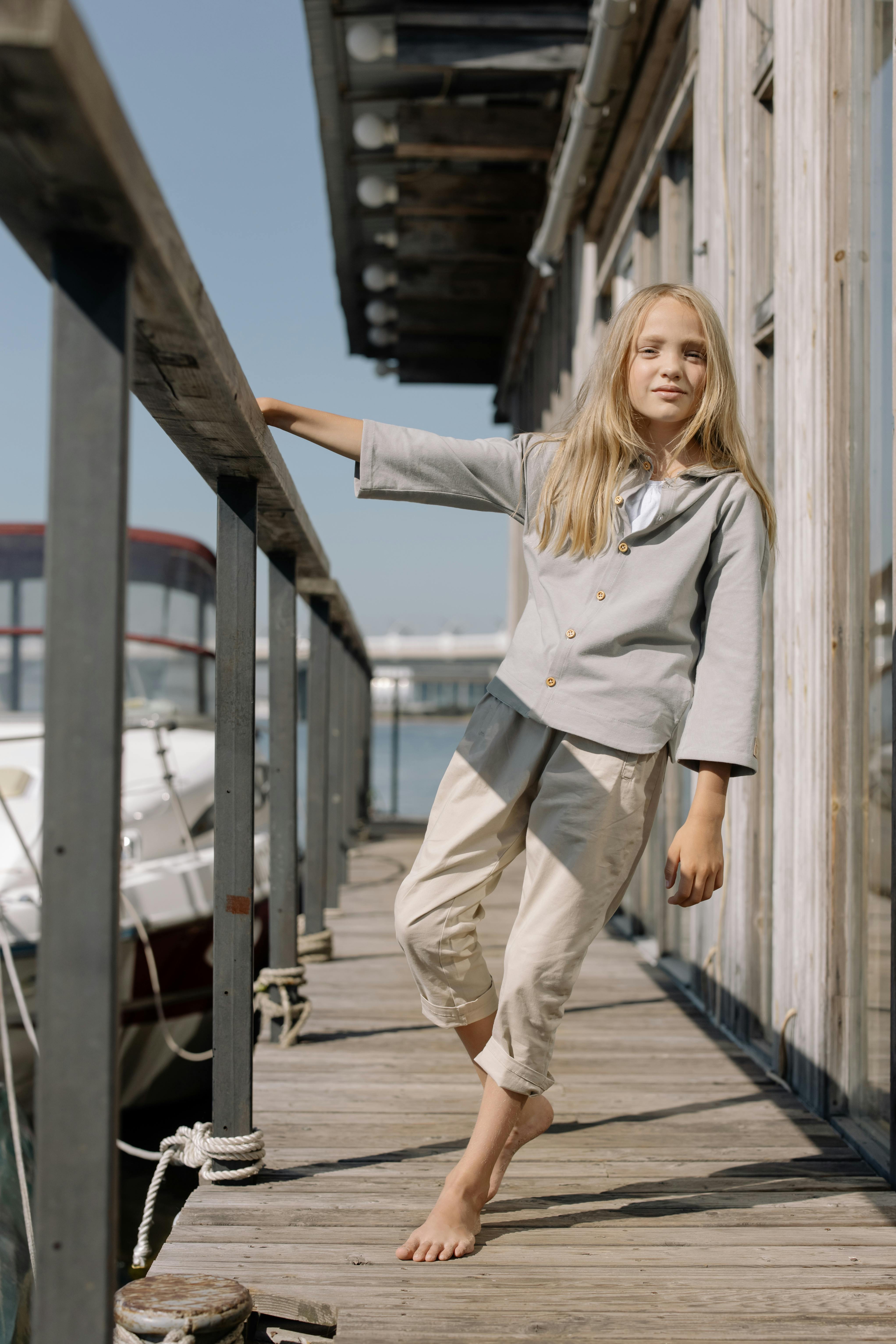 A Girl with Blonde Hair Standing Barefoot · Free Stock Photo