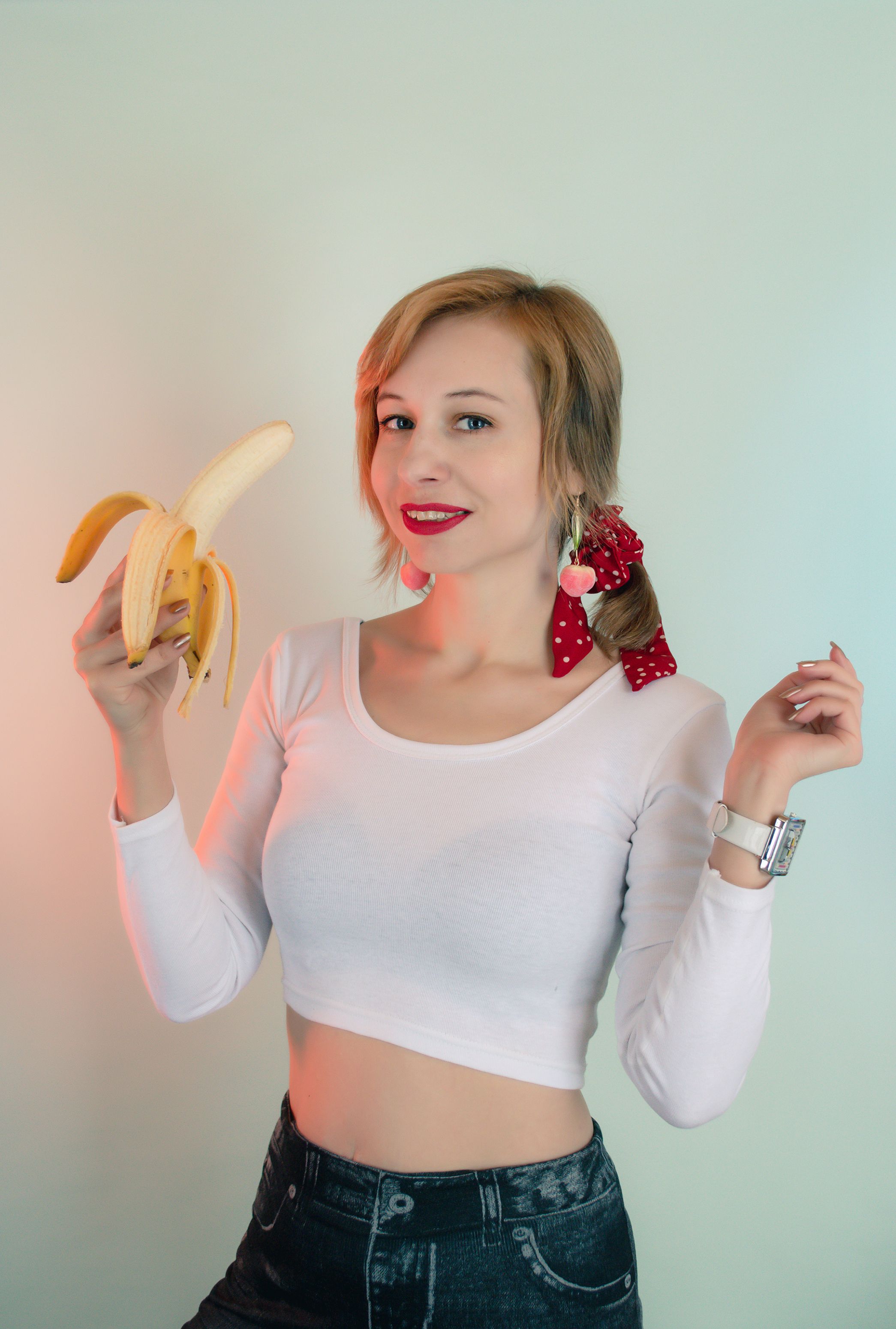 Cheerful female holding sweet banana in studio · Free Stock Photo