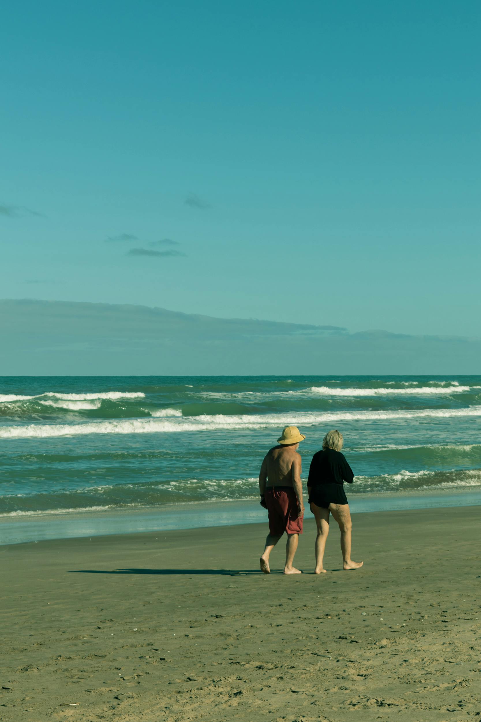 Two People Walking on the Beach · Free Stock Photo