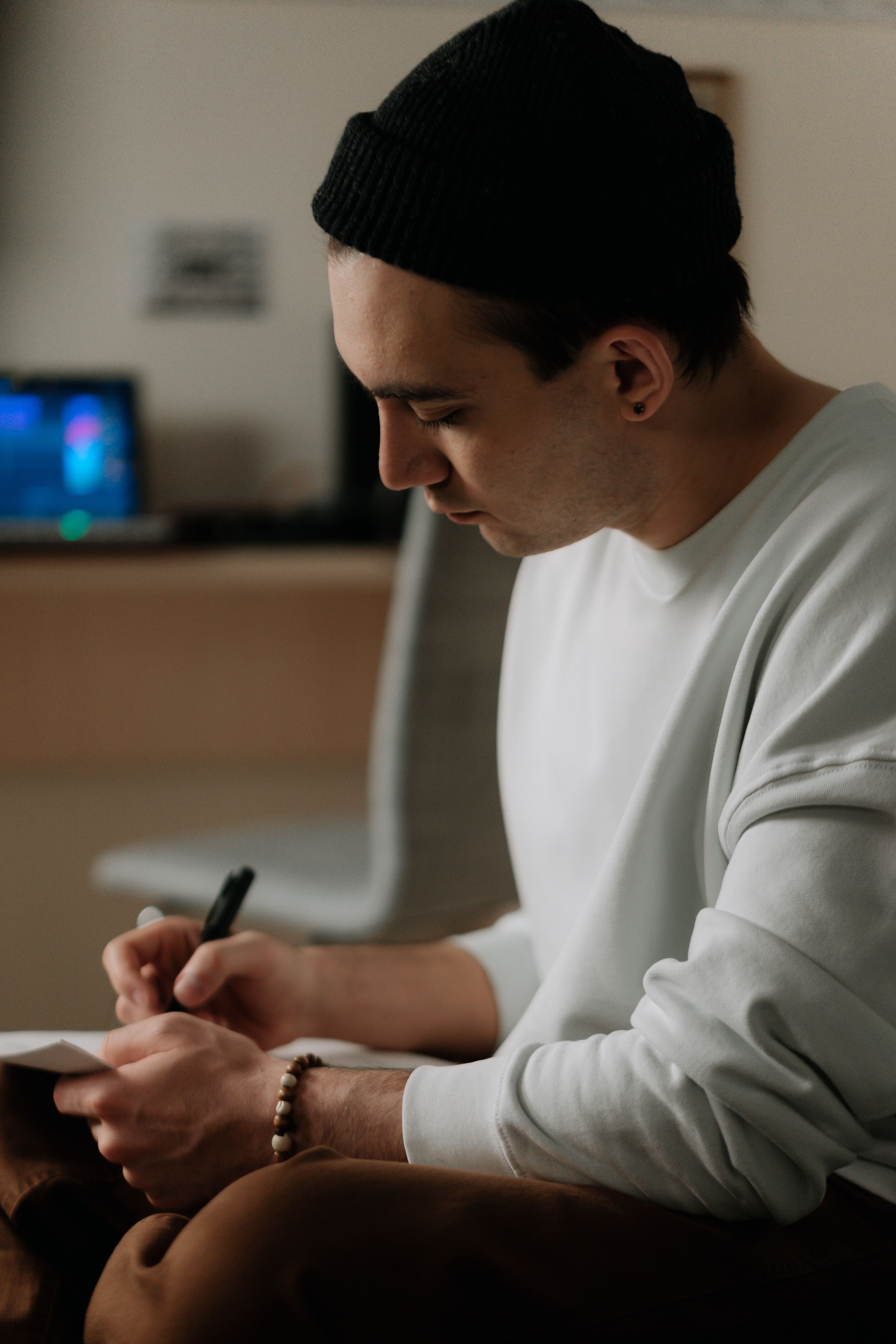 Person in Blue Denim Jacket Sitting on Chair While Writing · Free Stock ...