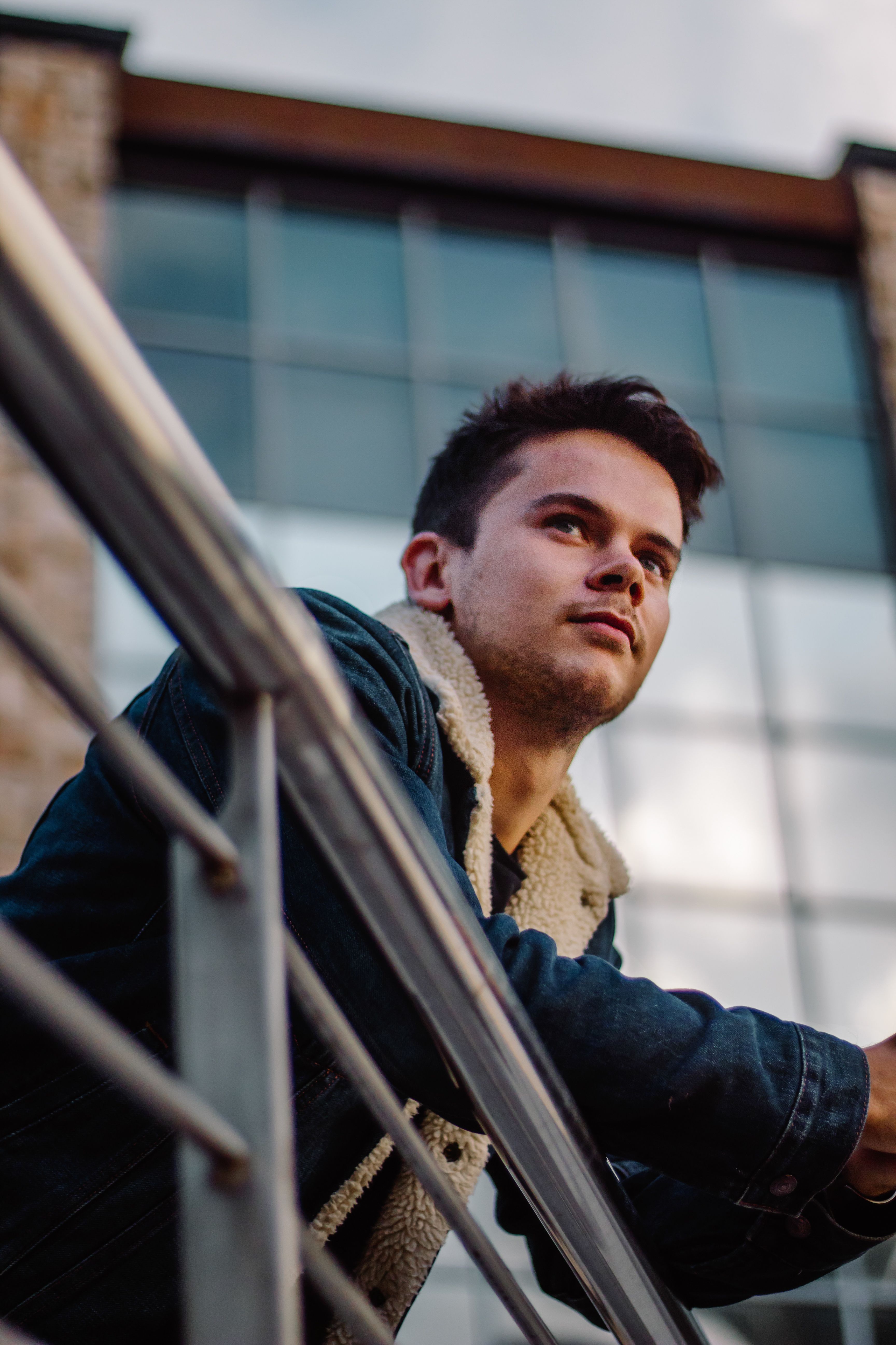 Handsome man standing near metal railing · Free Stock Photo