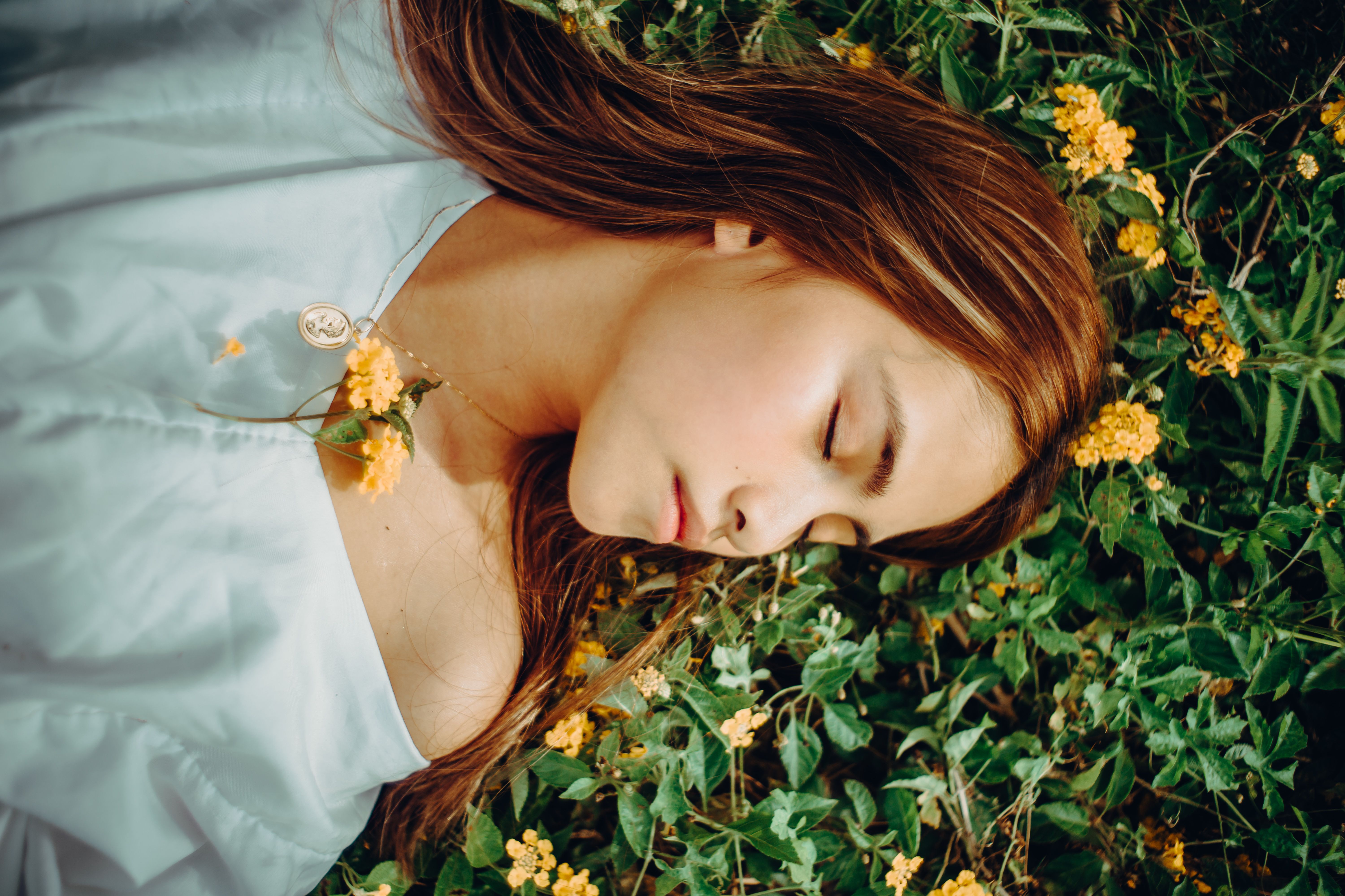 Woman Lying on Grass with a Yellow Flower on Her Chest · Free Stock Photo