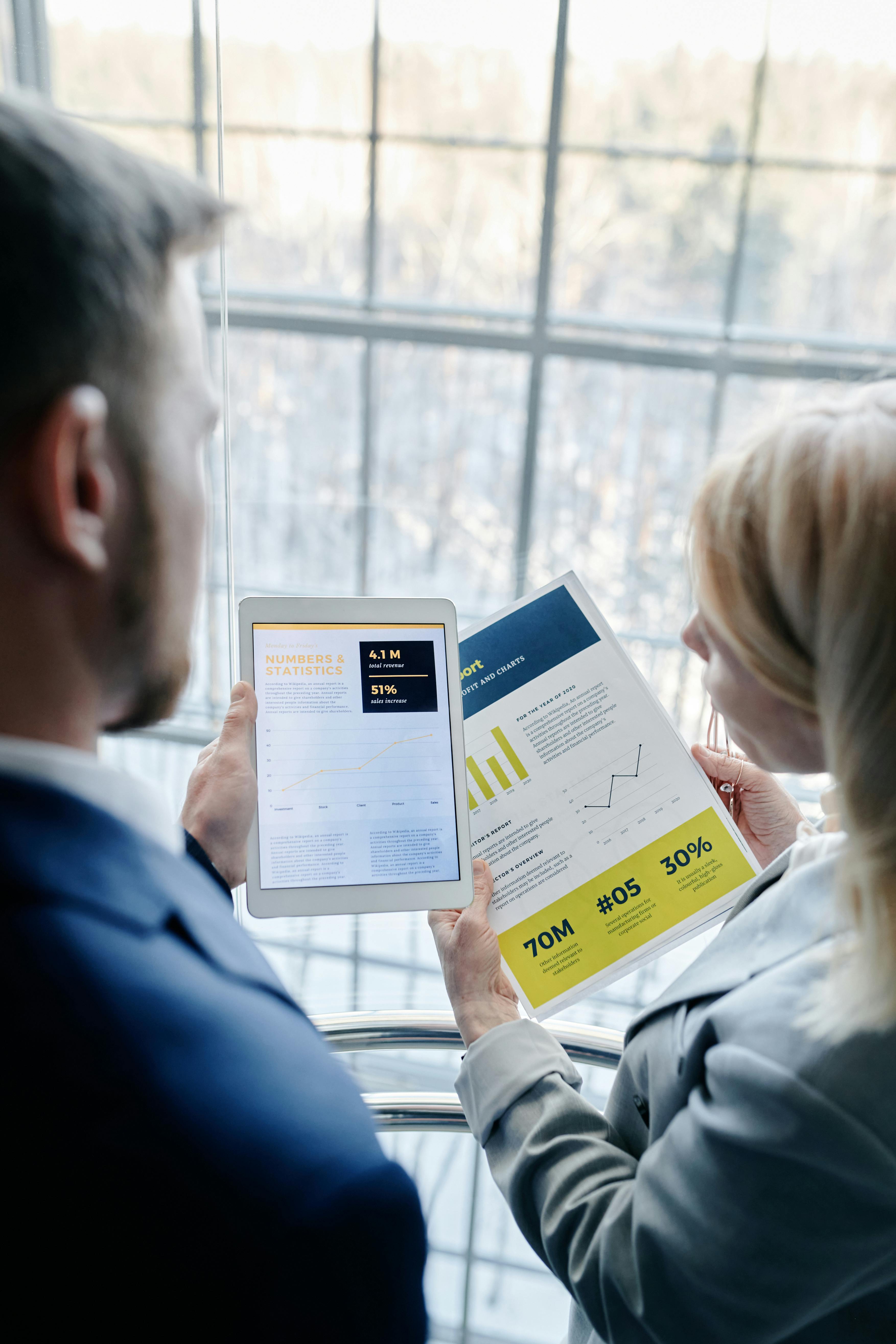 Two People Sharing Paper and Digital Information · Free Stock Photo