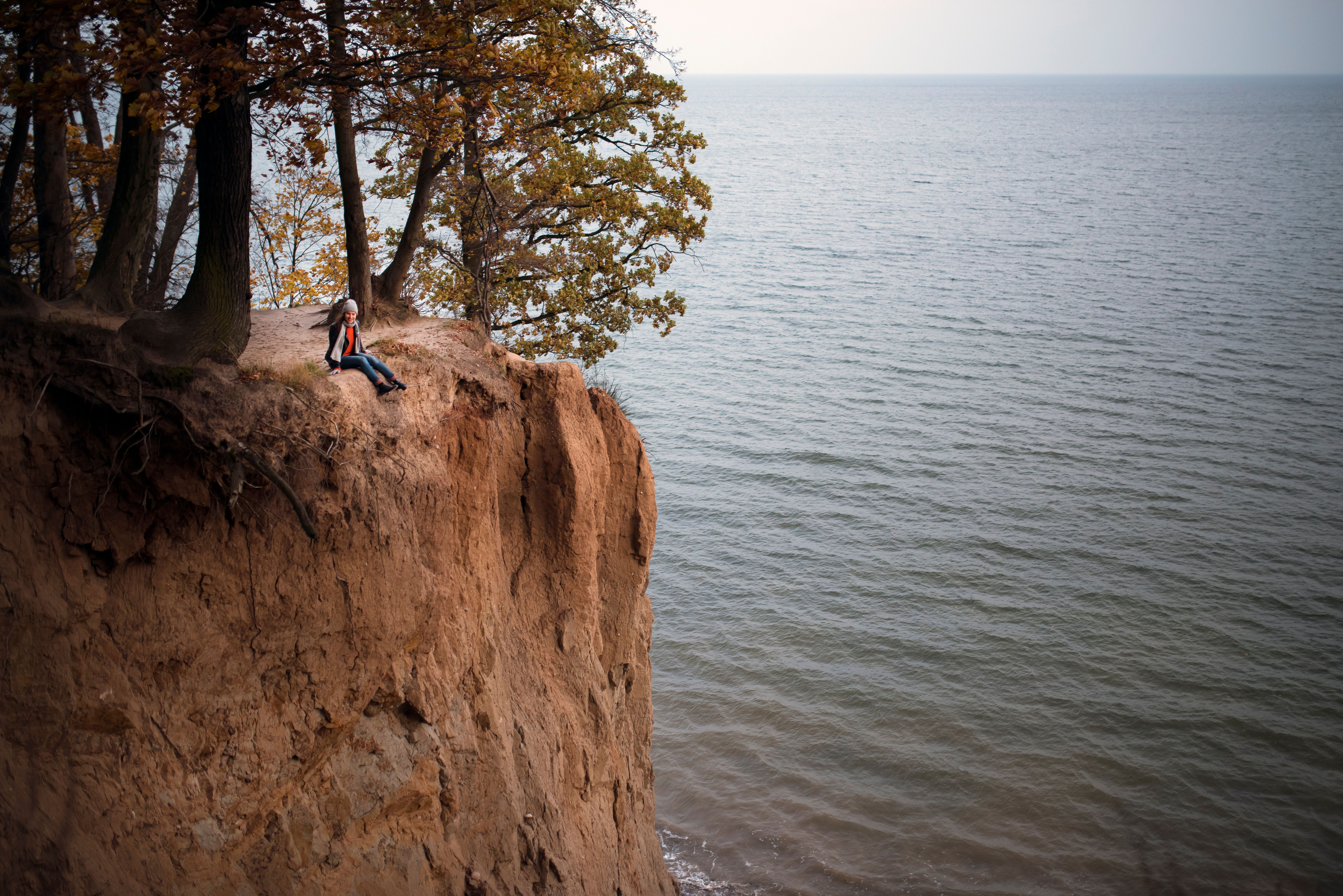 Woman Sitting on Brown Cliff · Free Stock Photo
